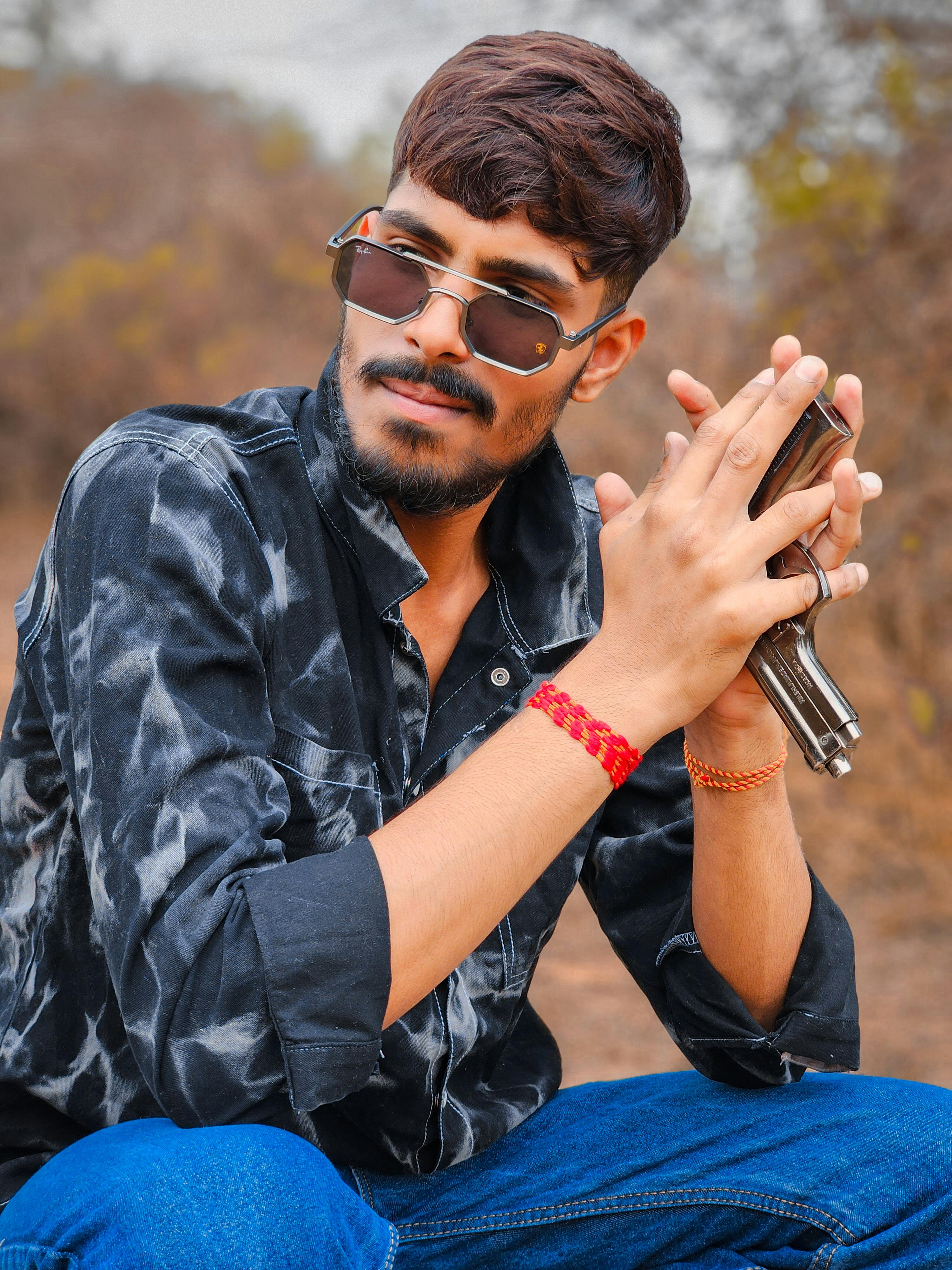 Portrait of a Stylish Young Man Ho;lding a Revolver · Free Stock Photo