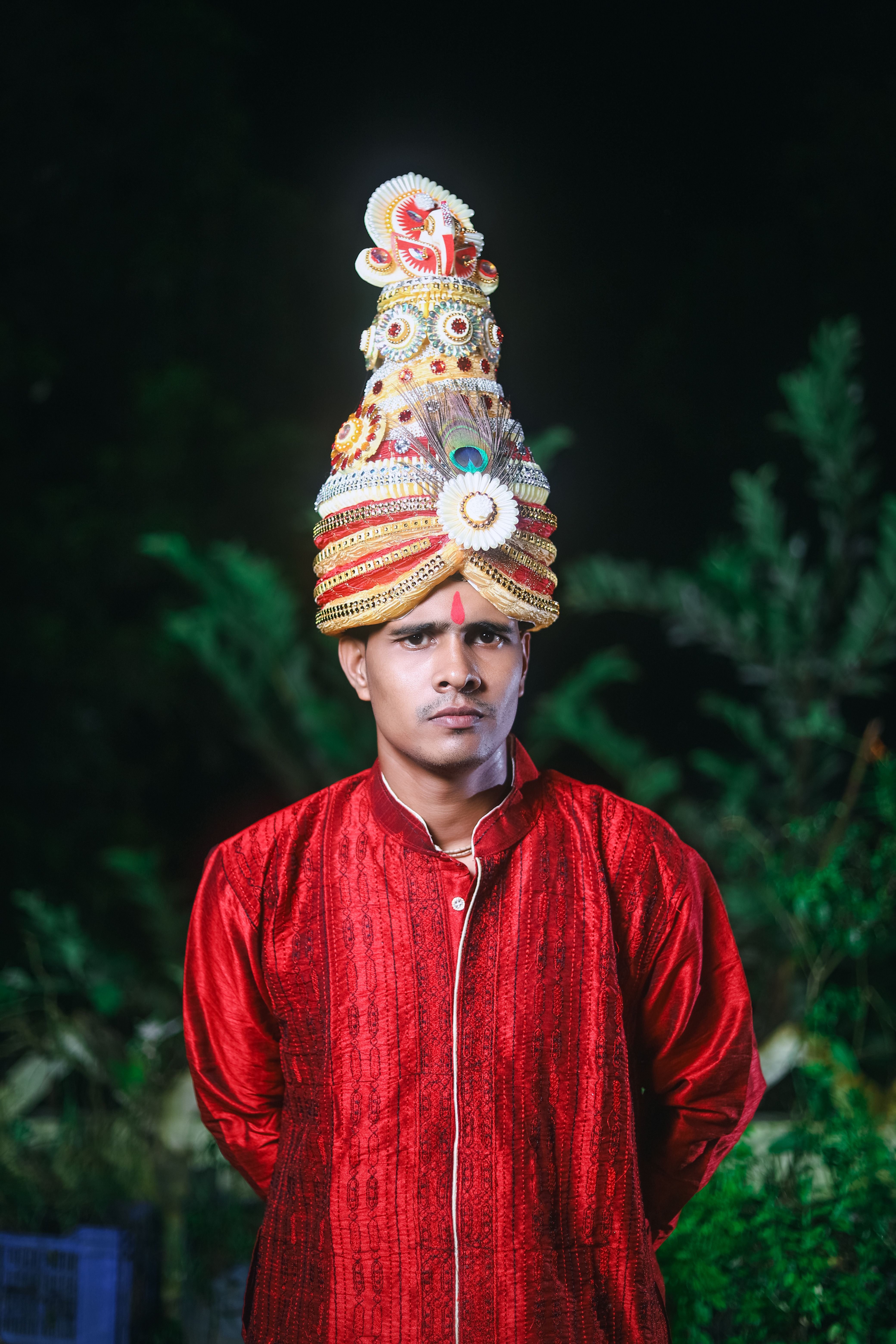 A man in traditional indian clothing with a large hat on his head ...