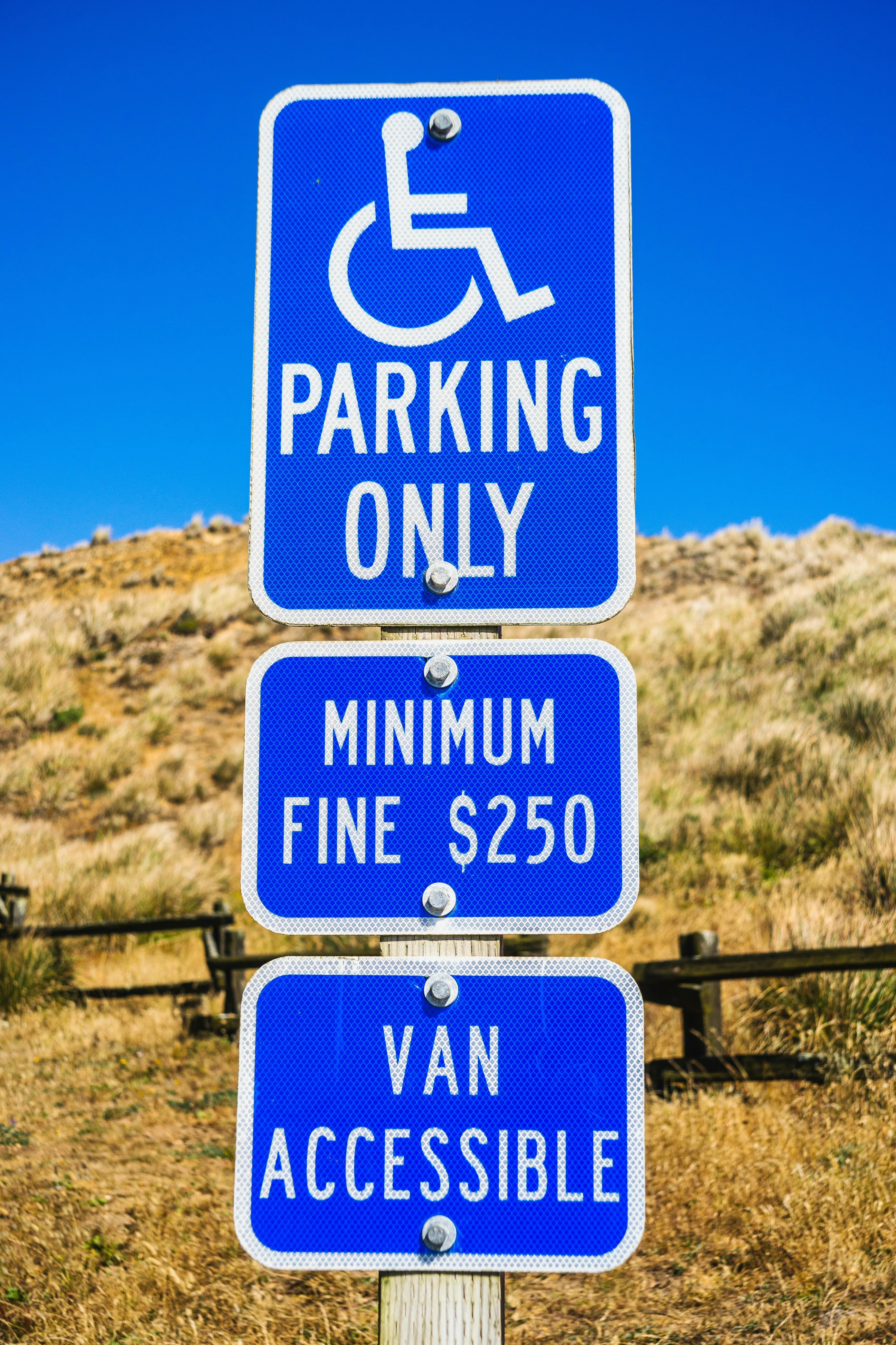 A blue sign with the words parking only and a blue van · Free Stock Photo