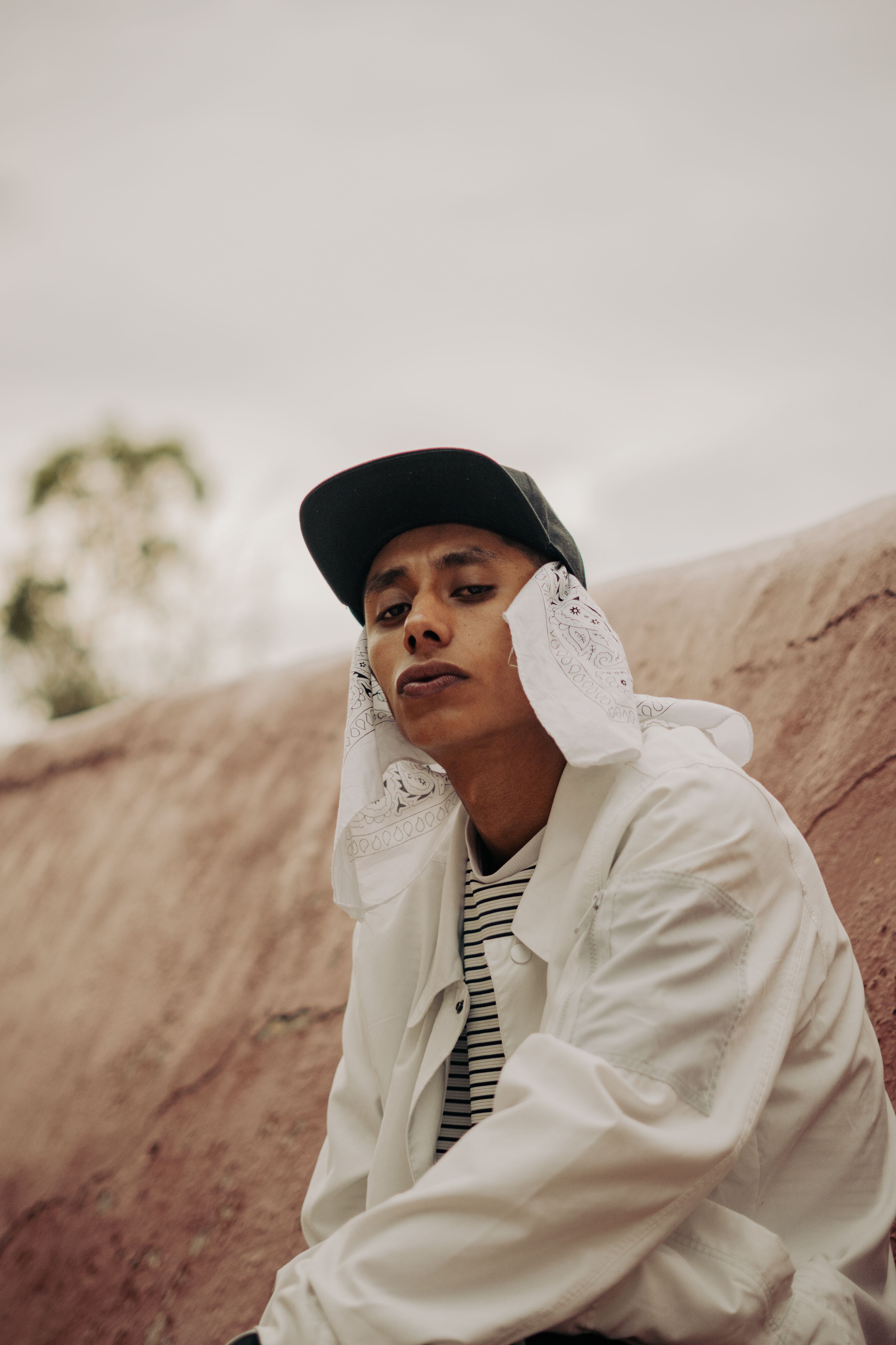 Man in White Jacket Leaning on Brick Wall · Free Stock Photo