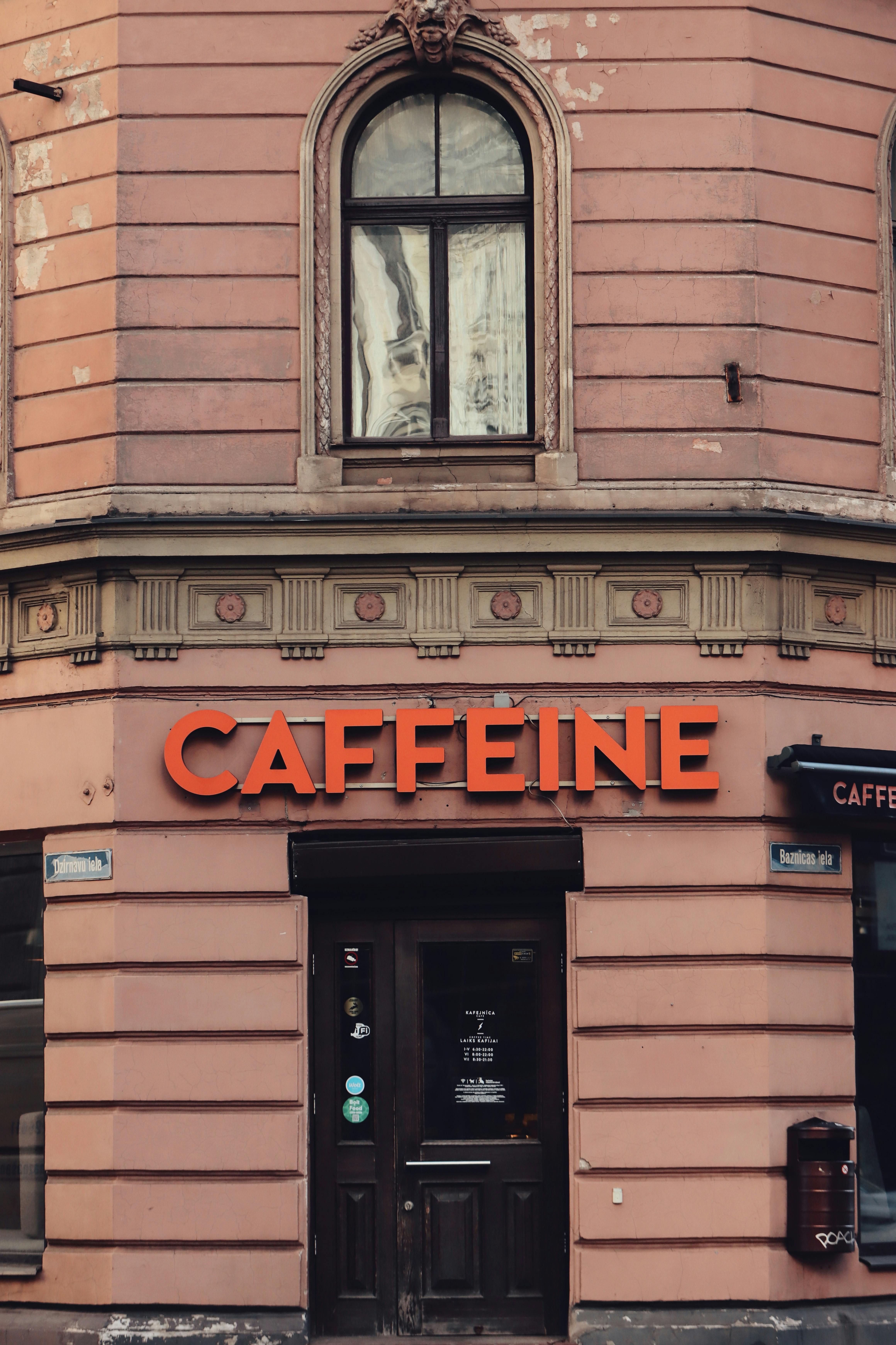 Building Facade with a Caffeine Sign · Free Stock Photo