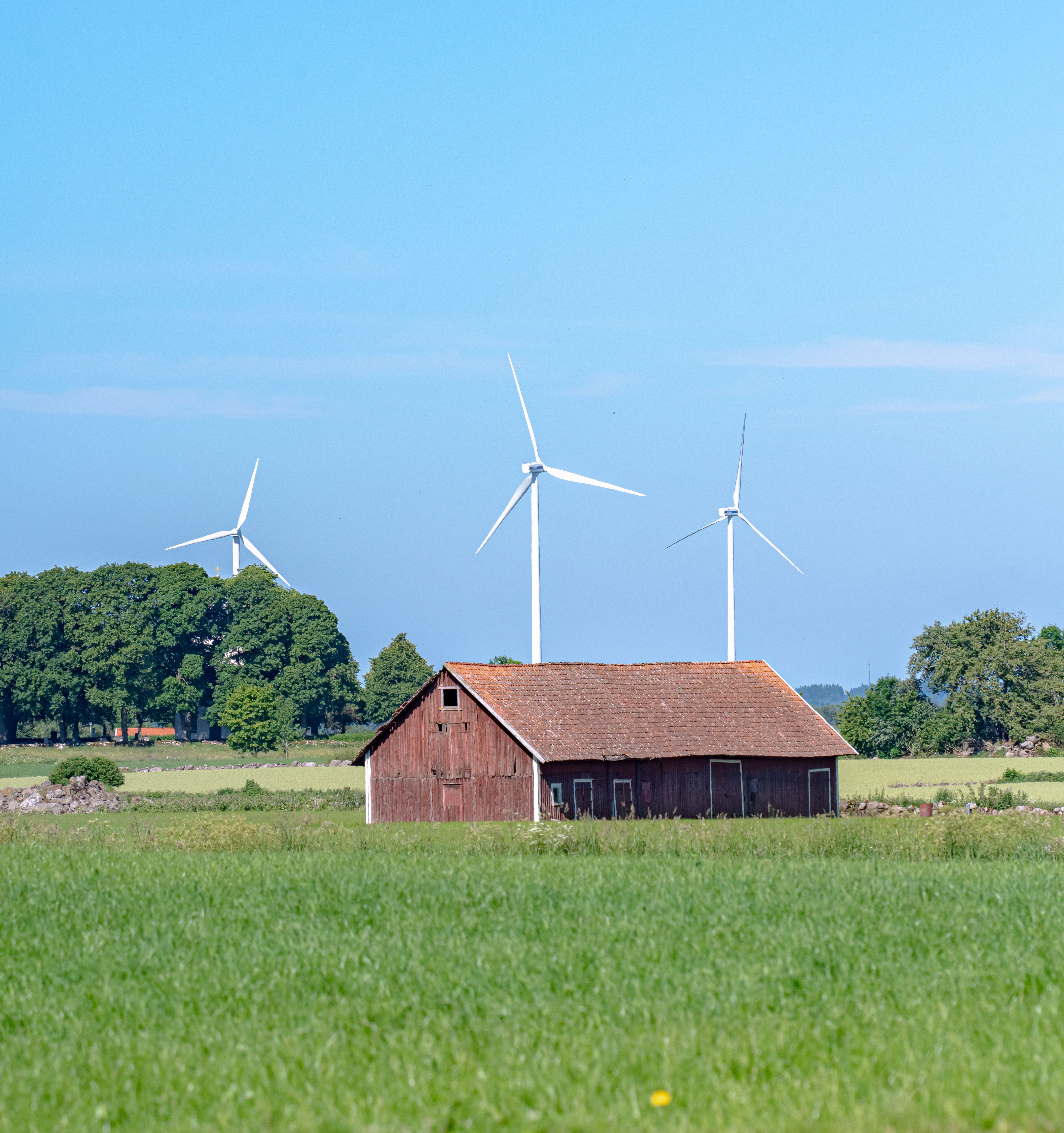 A barn and wind turbines in a field · Free Stock Photo