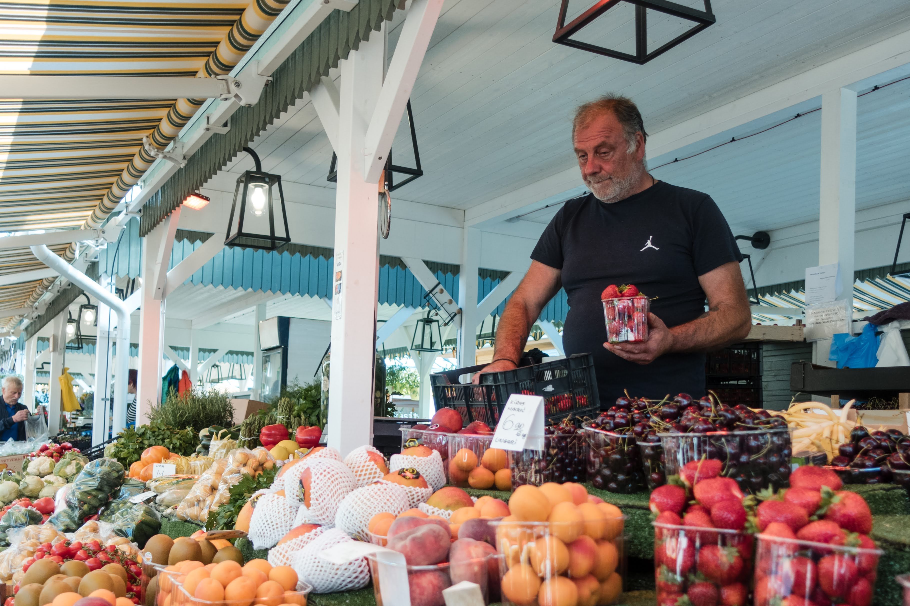 Man Selling Fruit at an Outdoor Market Stall · Free Stock Photo