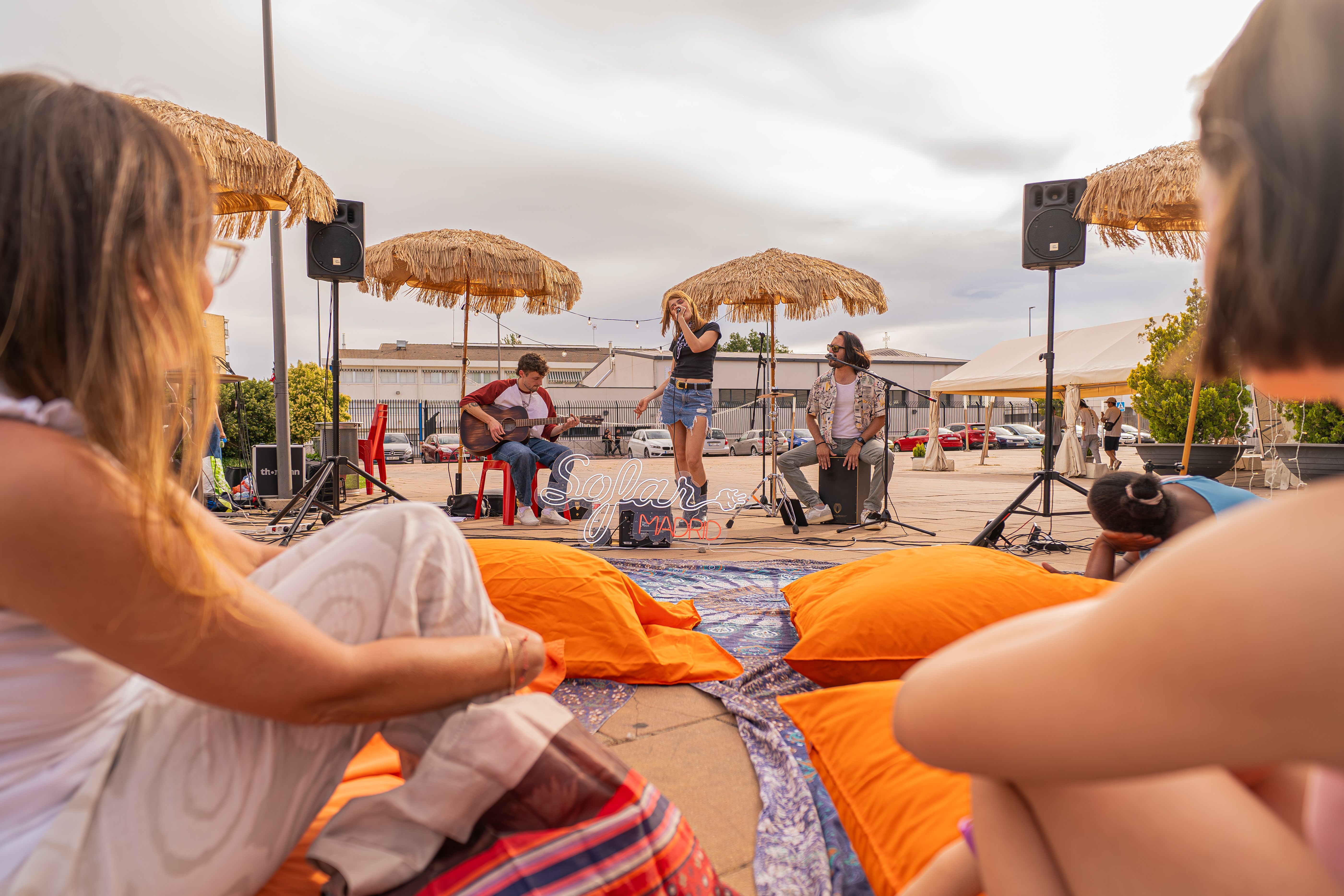 Women Sitting on Pillows Watching Concert of Small Niche Band · Free ...