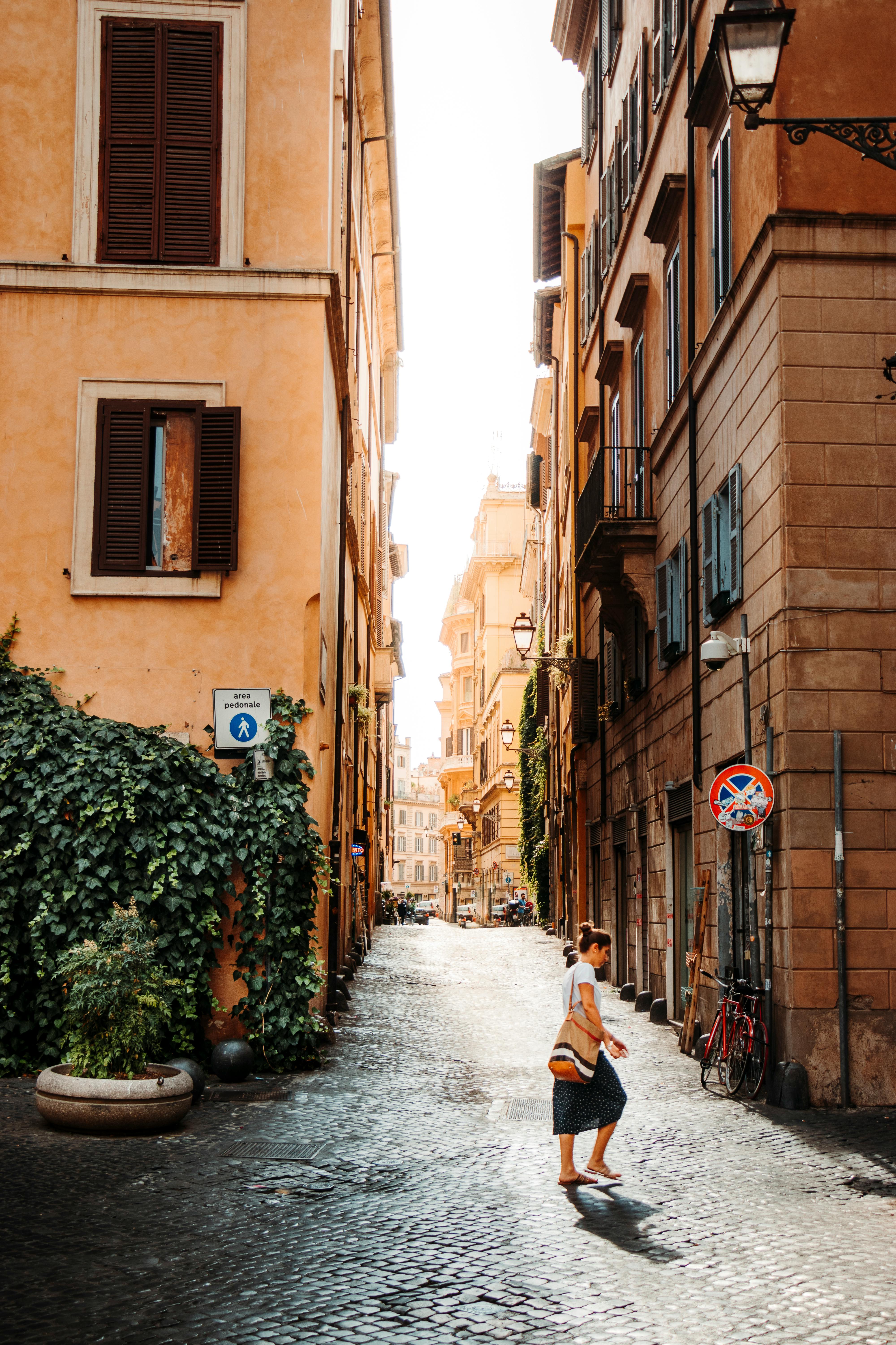 Photo of Woman Walking Between Buildings · Free Stock Photo