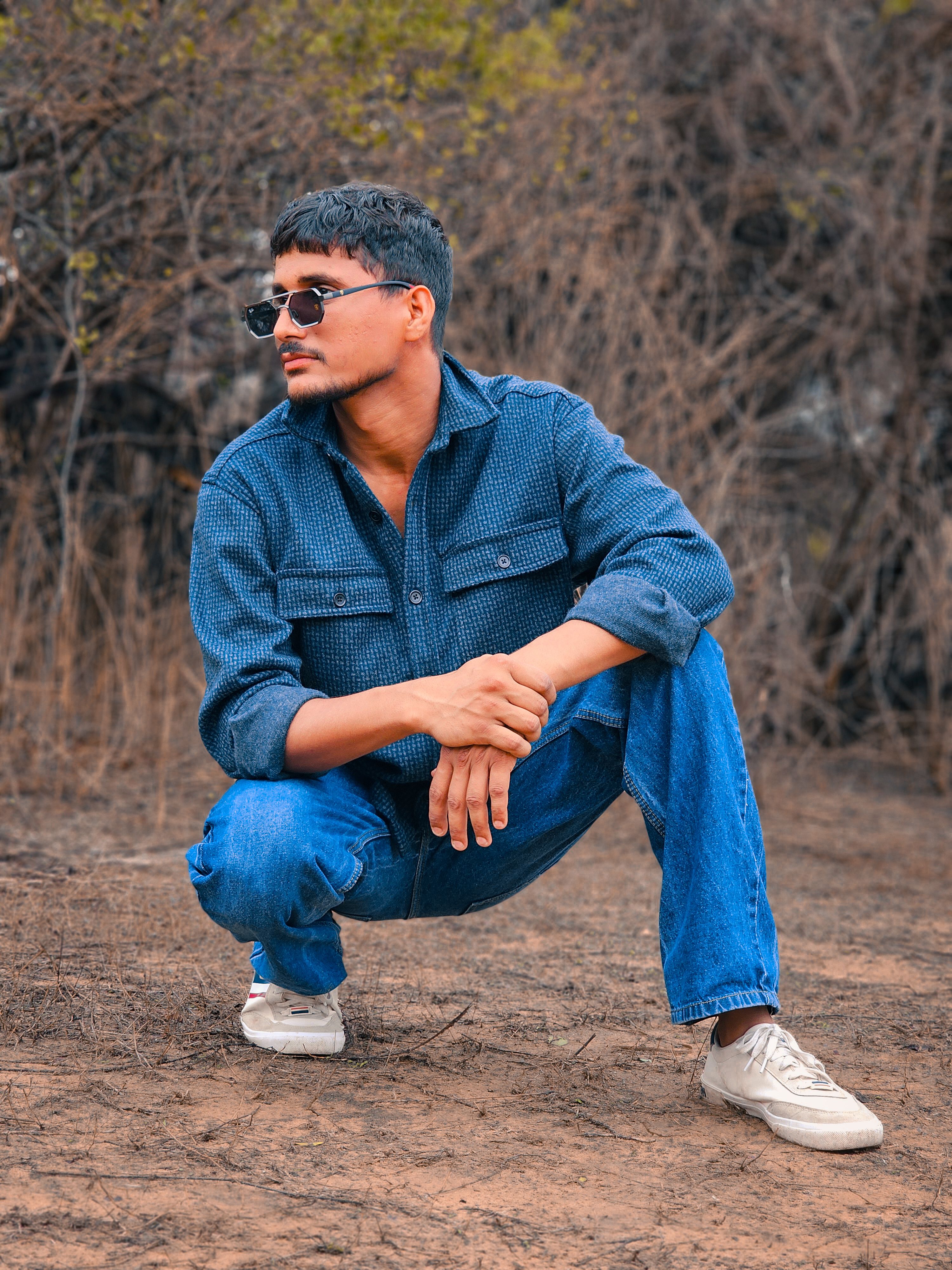 Portrait of a Male Model Wearing Sunglasses and a Shirt Crouching ...