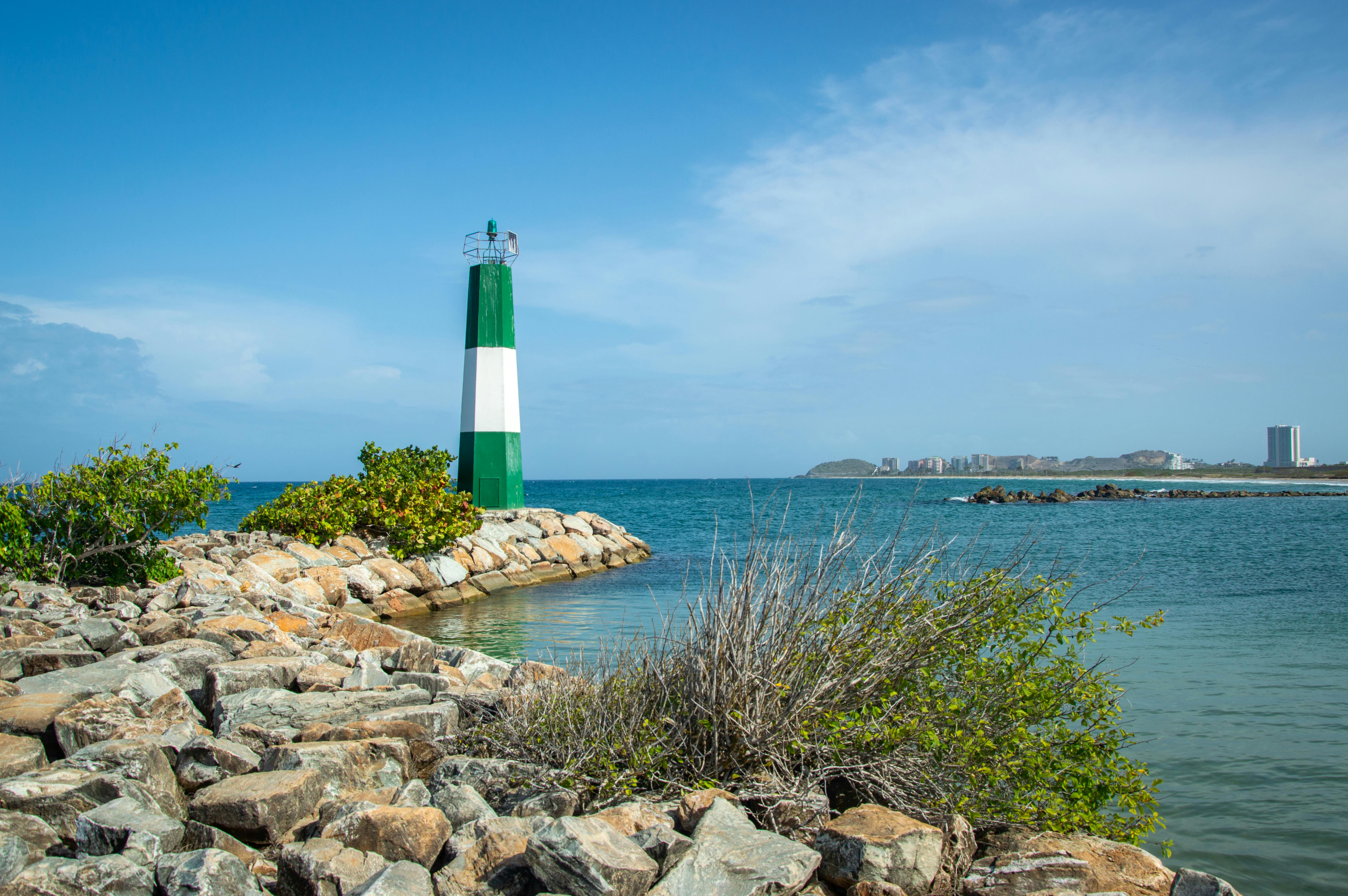 Red and White Lighthouse on Land · Free Stock Photo
