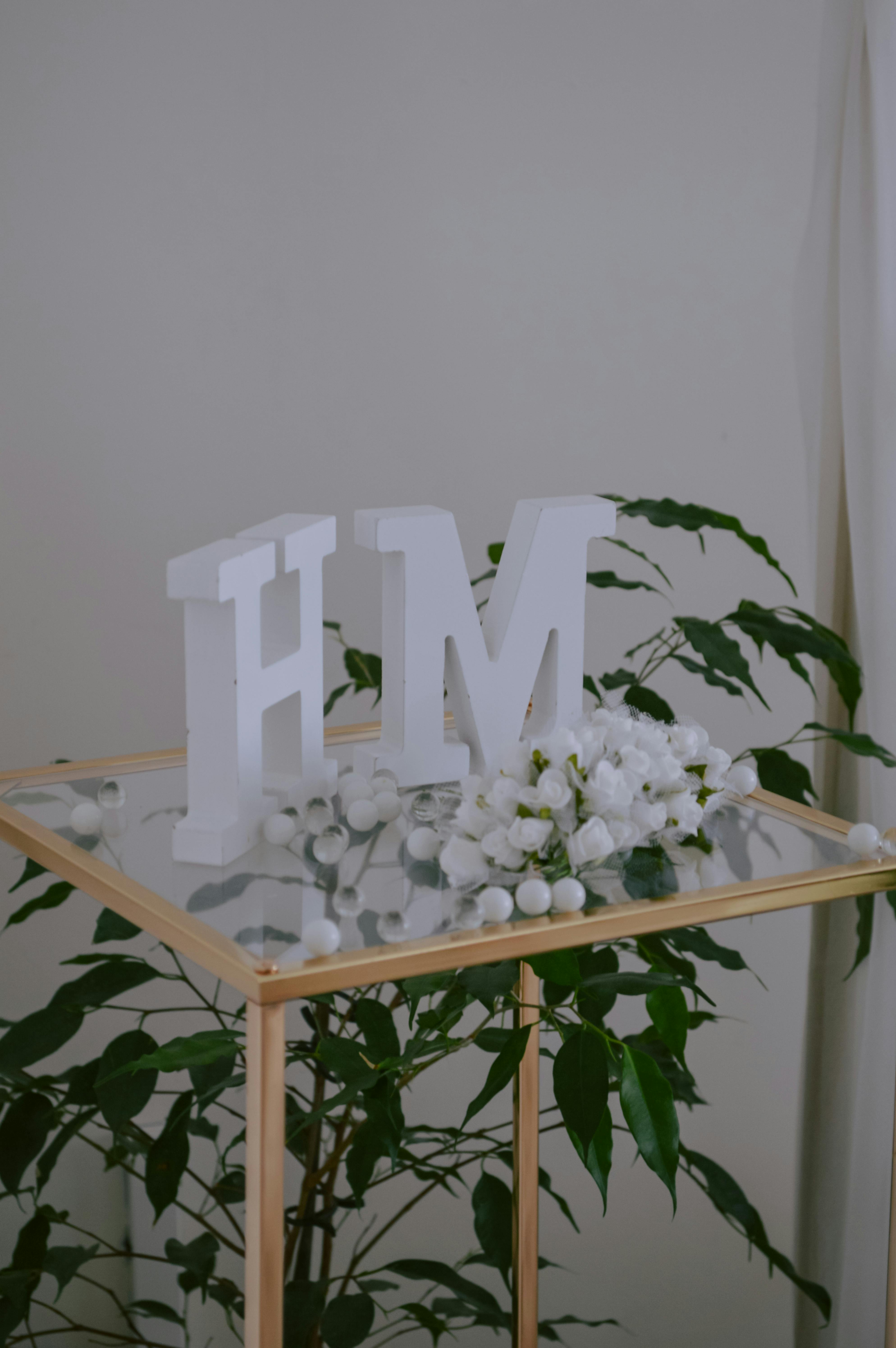 White Decorative Letters on a Glass Table with Flowers · Free Stock Photo