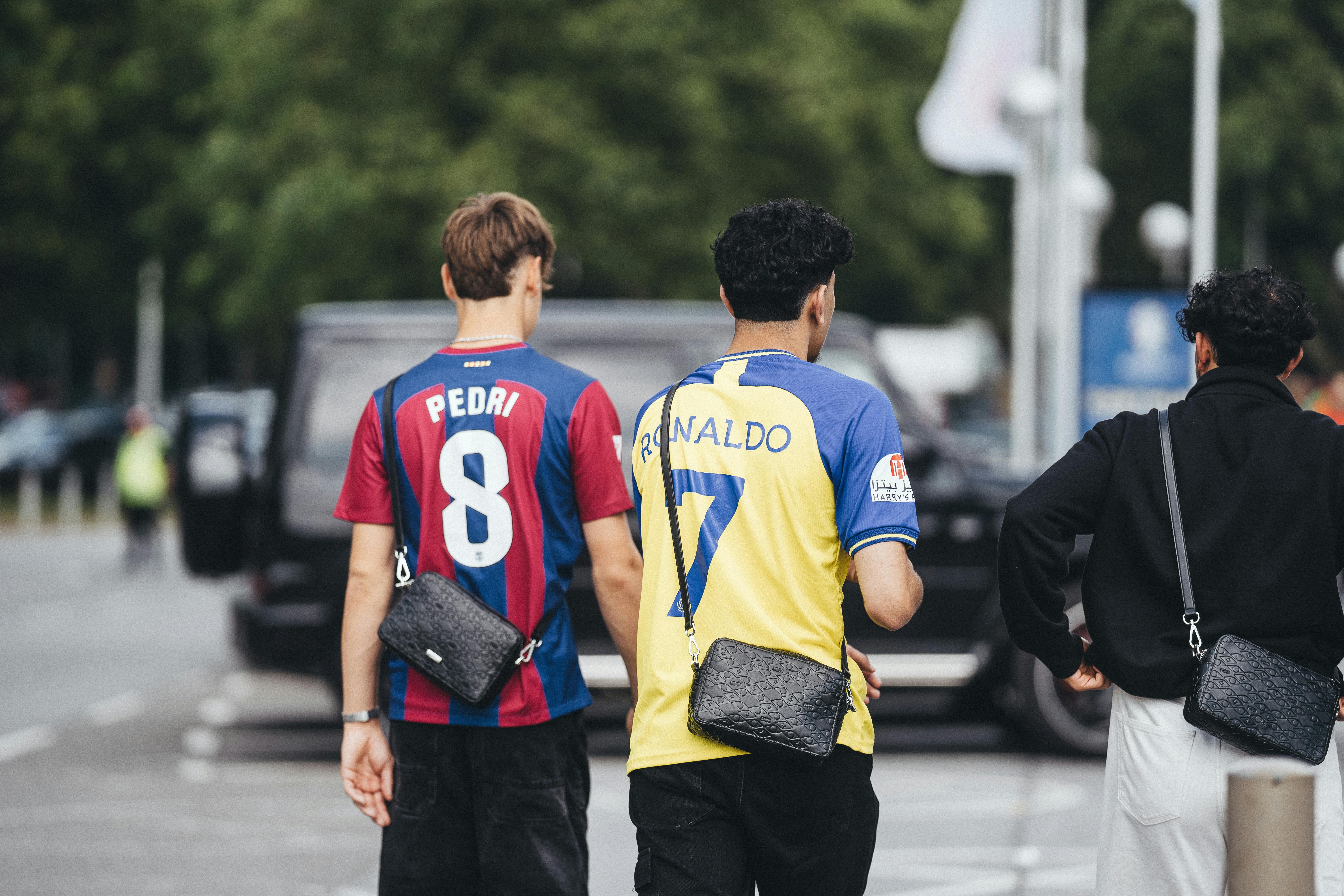 Back View of Two Boys Wearing Football Team Jerseys while Walking on ...