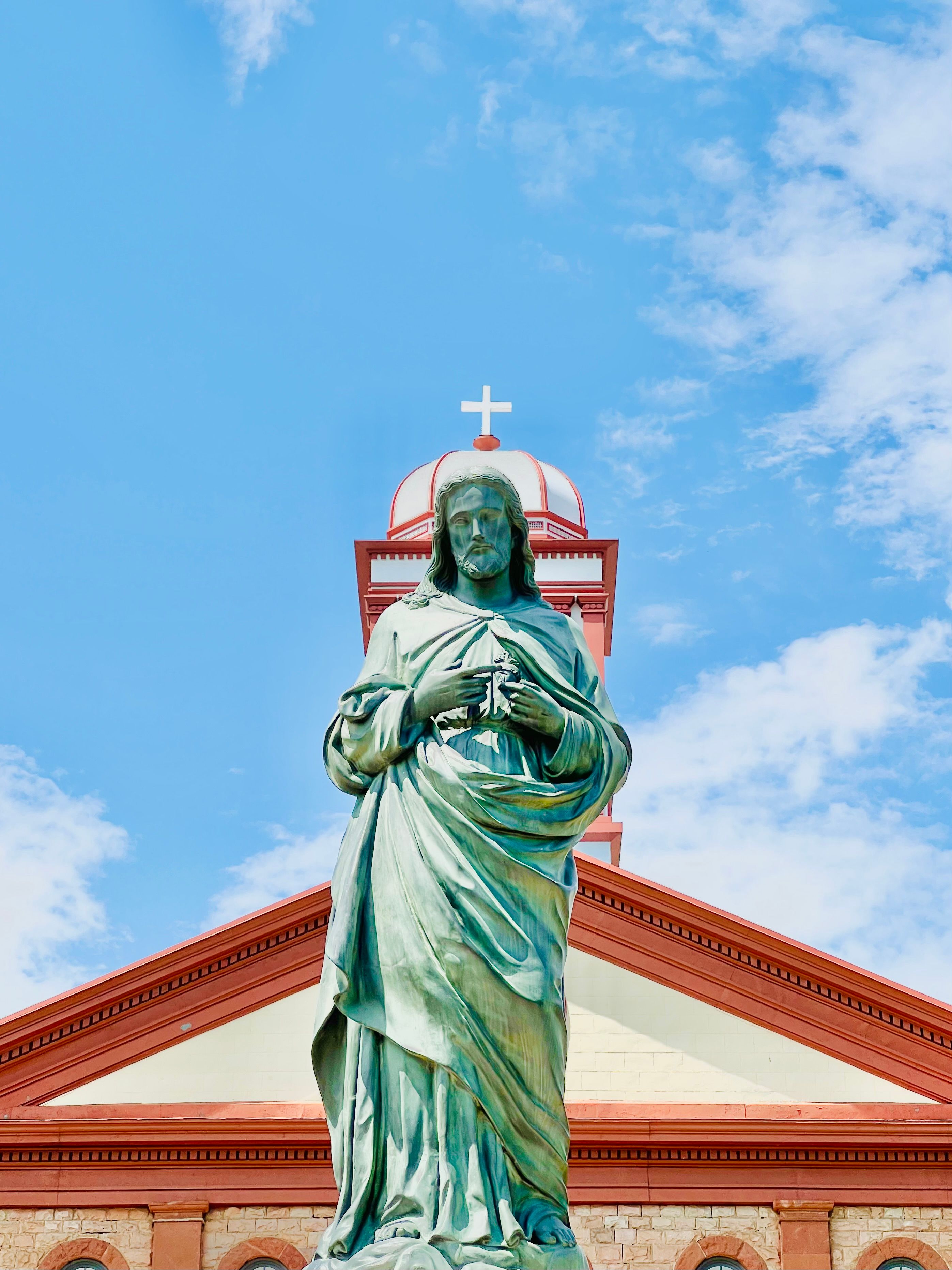 A statue of jesus in front of a church · Free Stock Photo