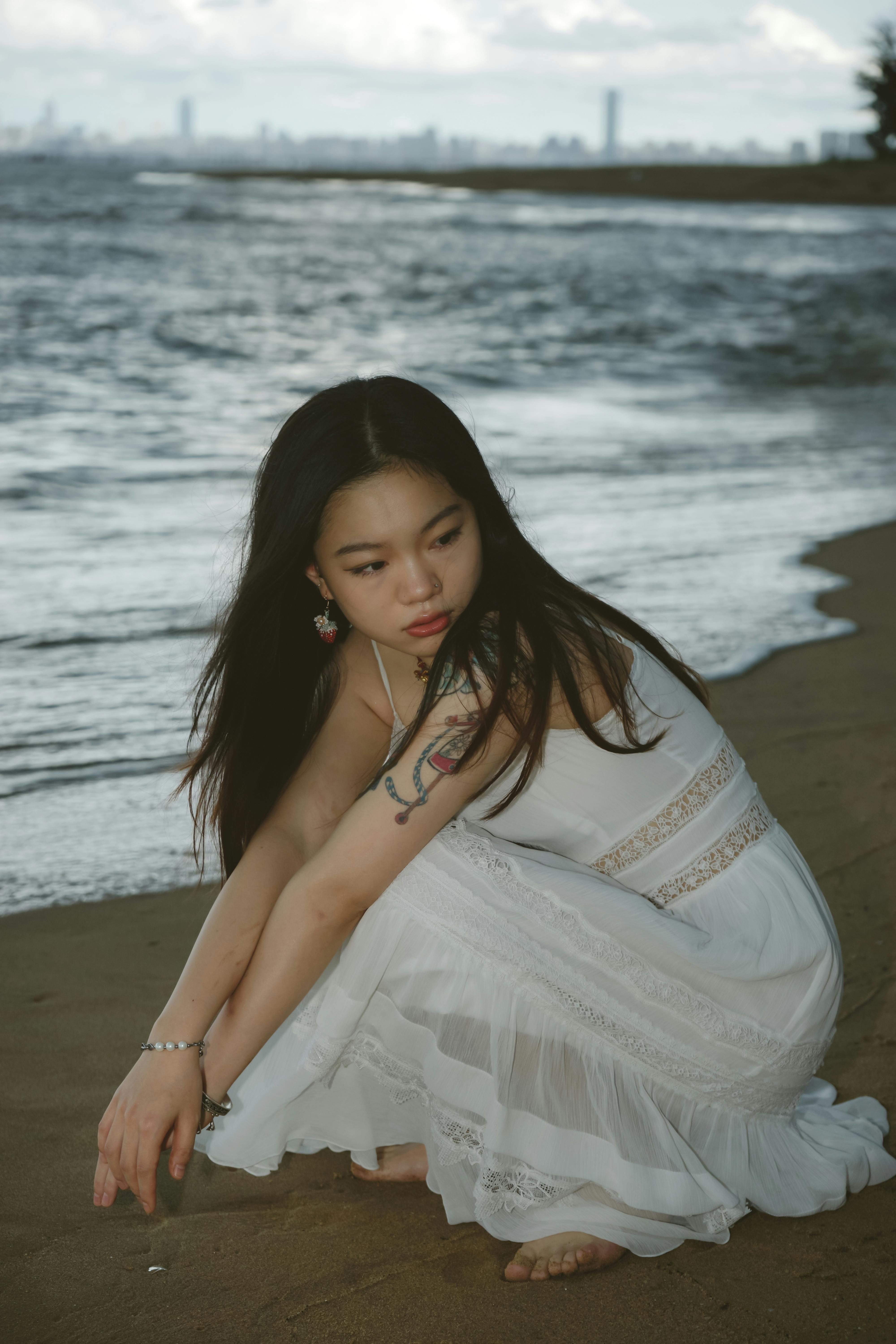Woman in White Dress Sitting on Beach · Free Stock Photo