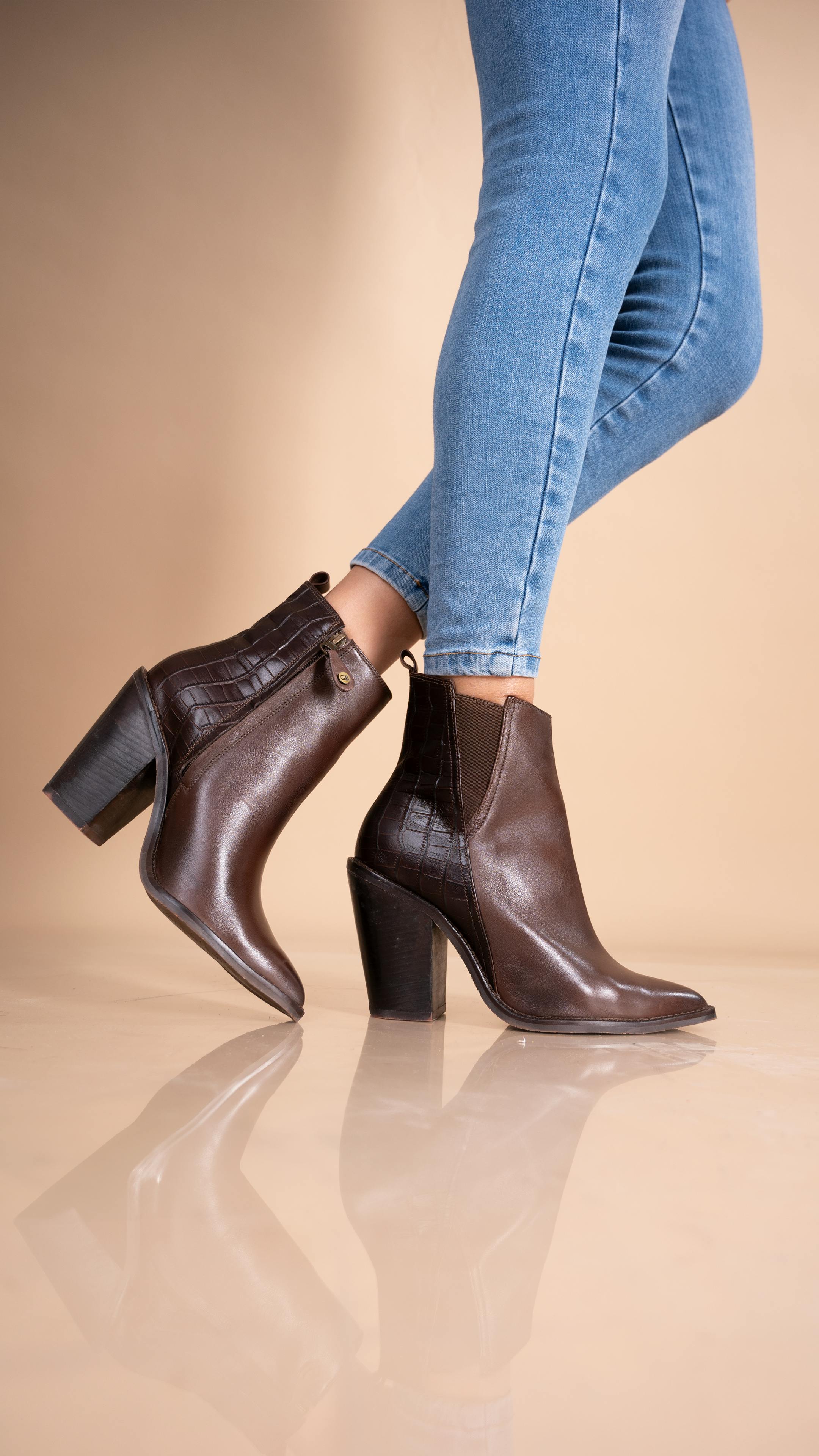 A Woman Wearing High Heeled Leather Boots · Free Stock Photo