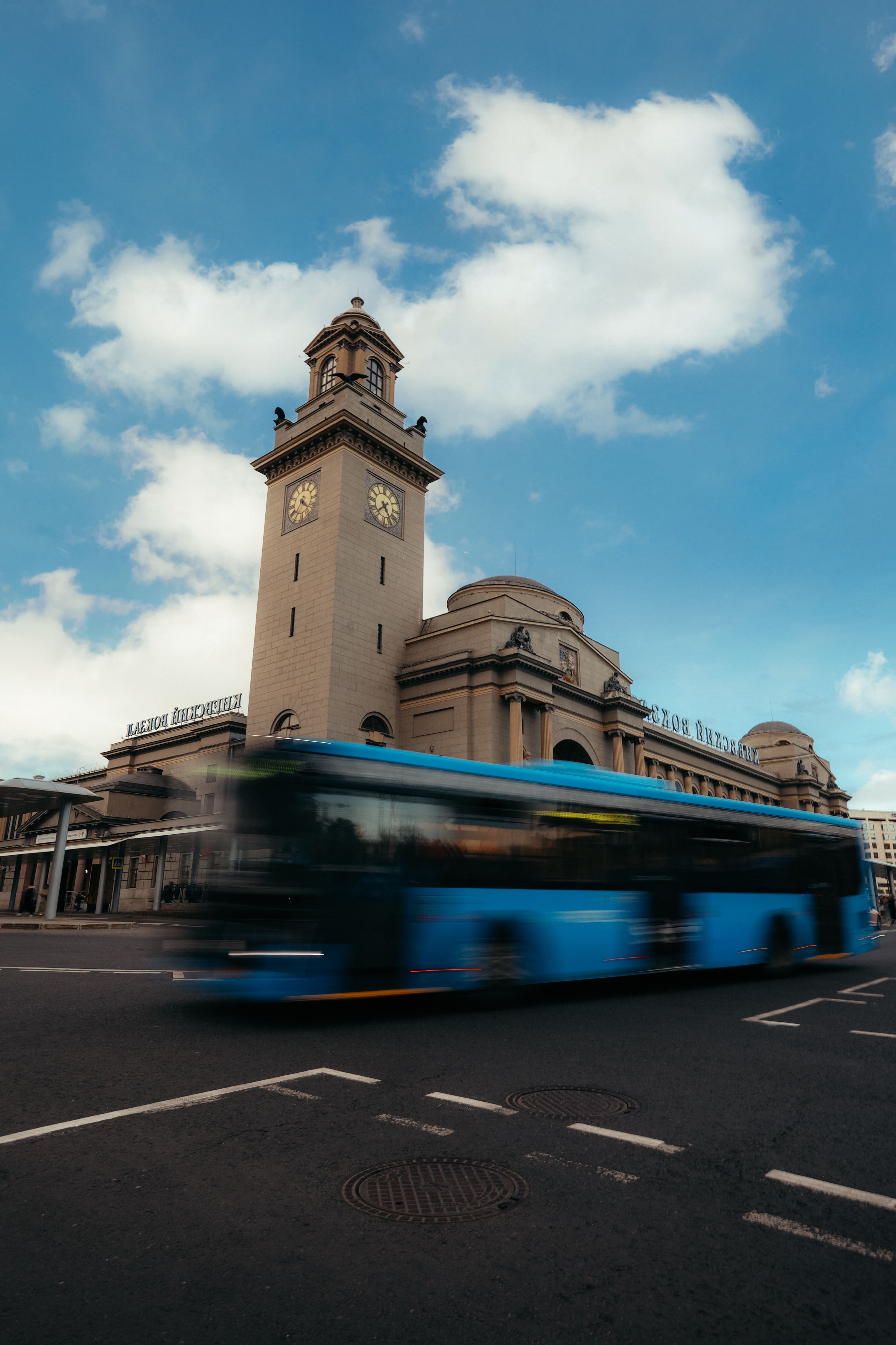 A blue bus is driving down the street · Free Stock Photo