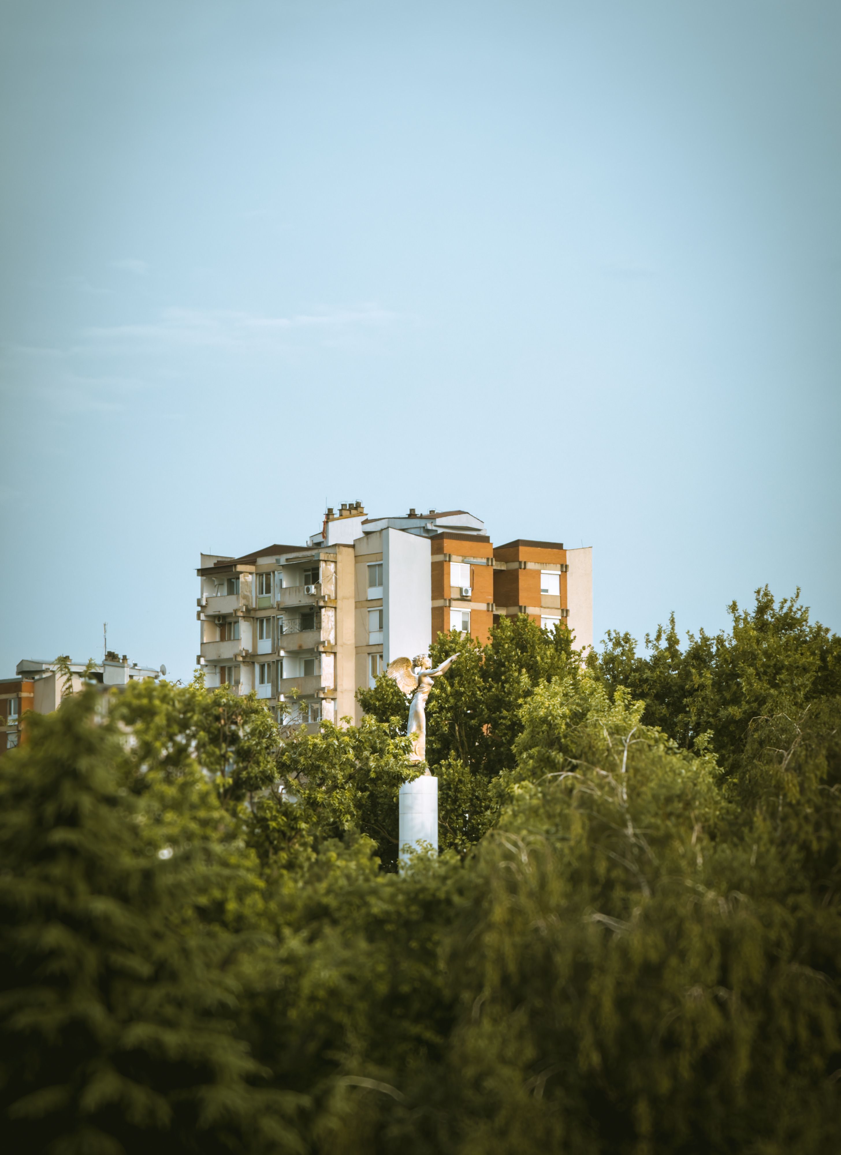 Urban Residential Building with Statue in Foreground · Free Stock Photo