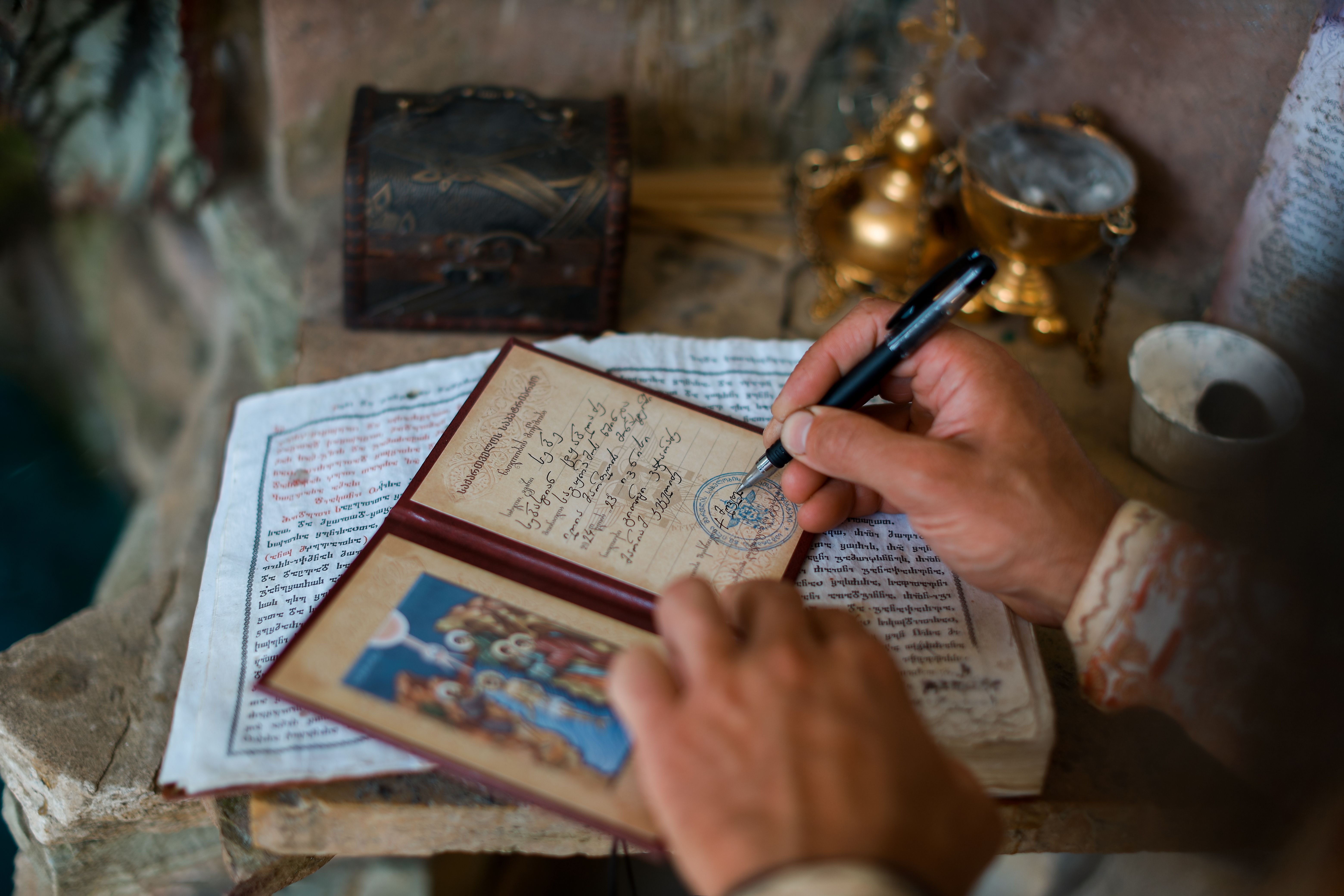A person writing in a book with a pen · Free Stock Photo