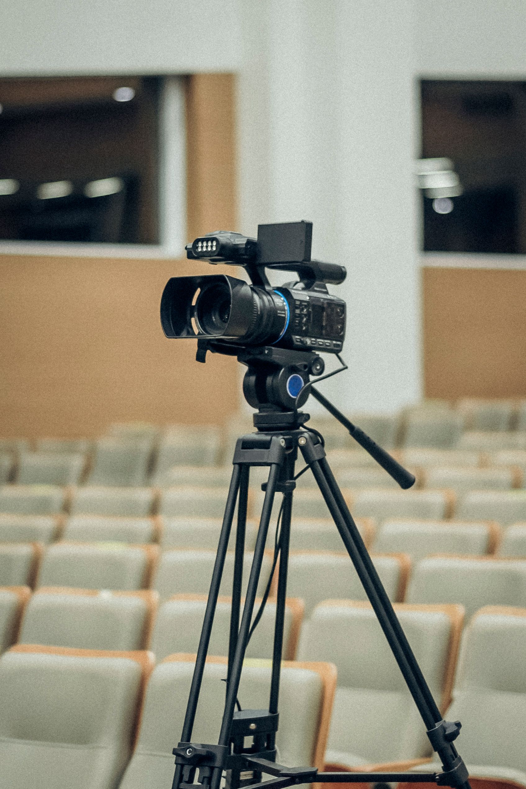 A video camera is set up in a room with chairs · Free Stock Photo