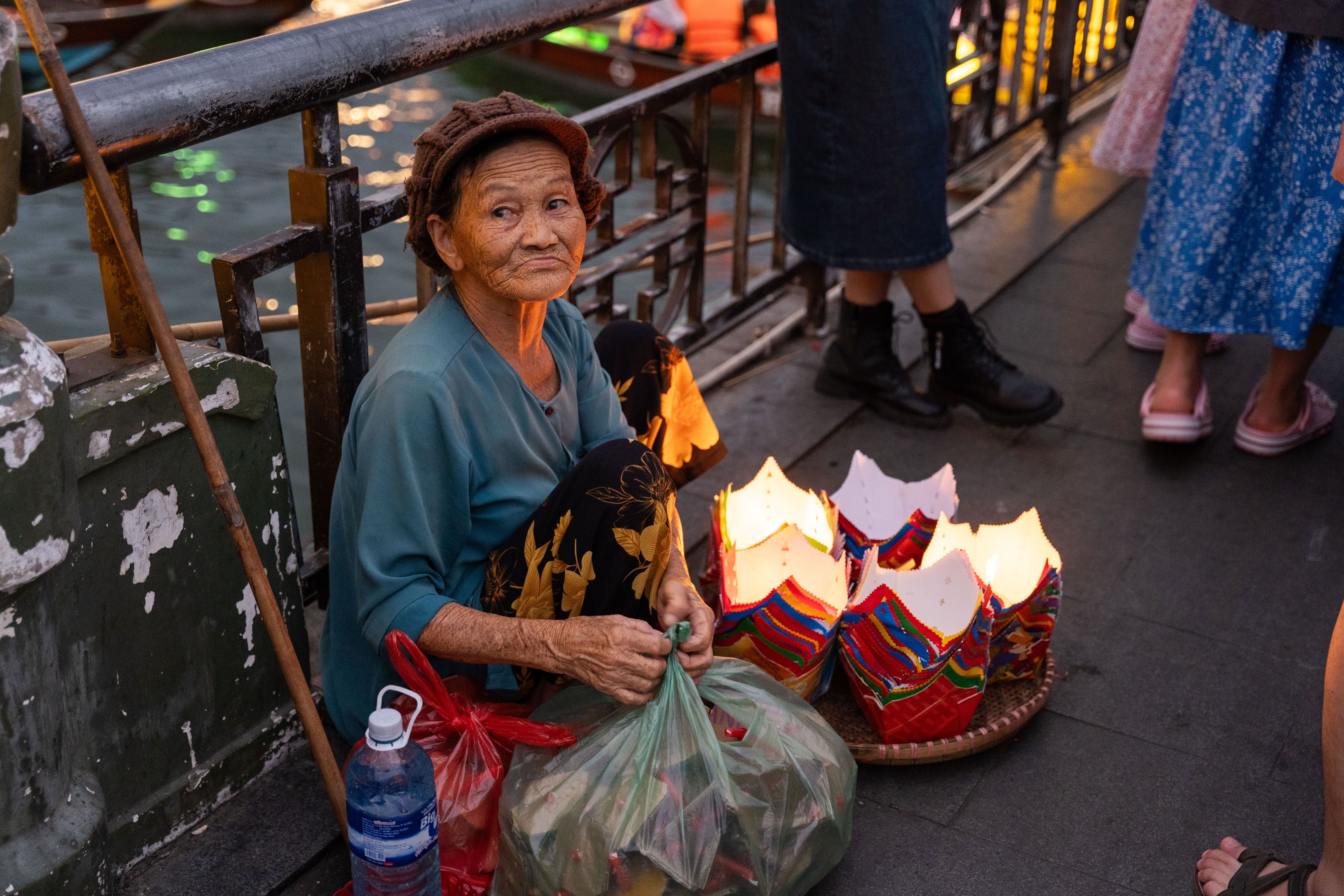 Senior Woman Selling Water Lanterns on a Bridge · Free Stock Photo