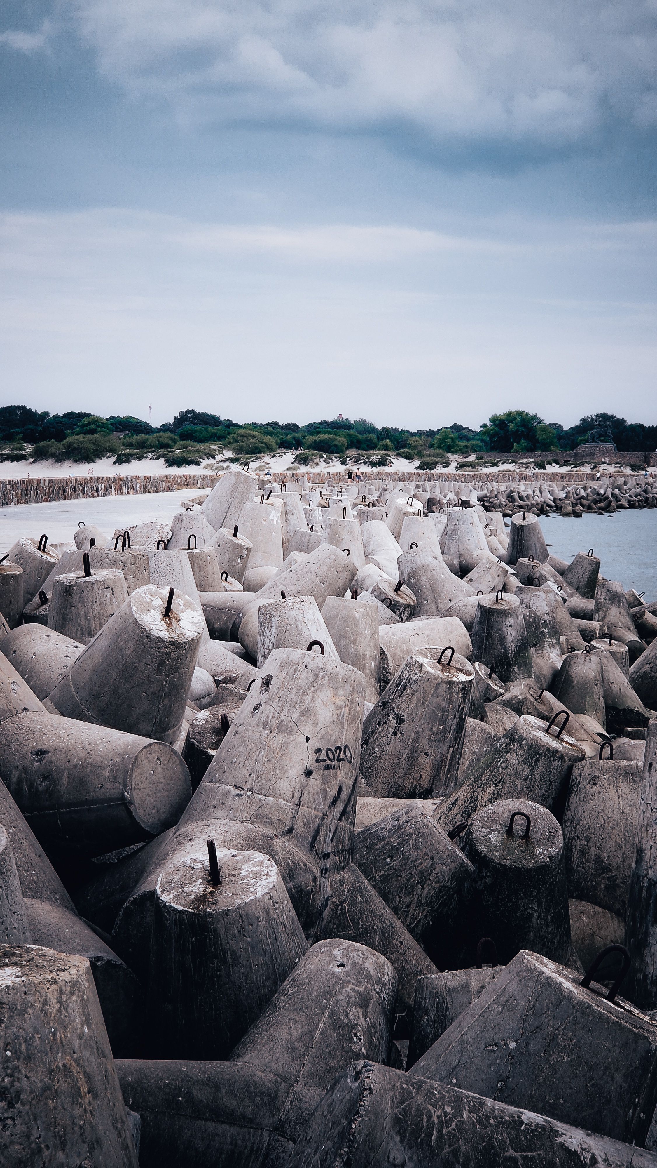 Concrete Breakwater between Beach and Sea · Free Stock Photo
