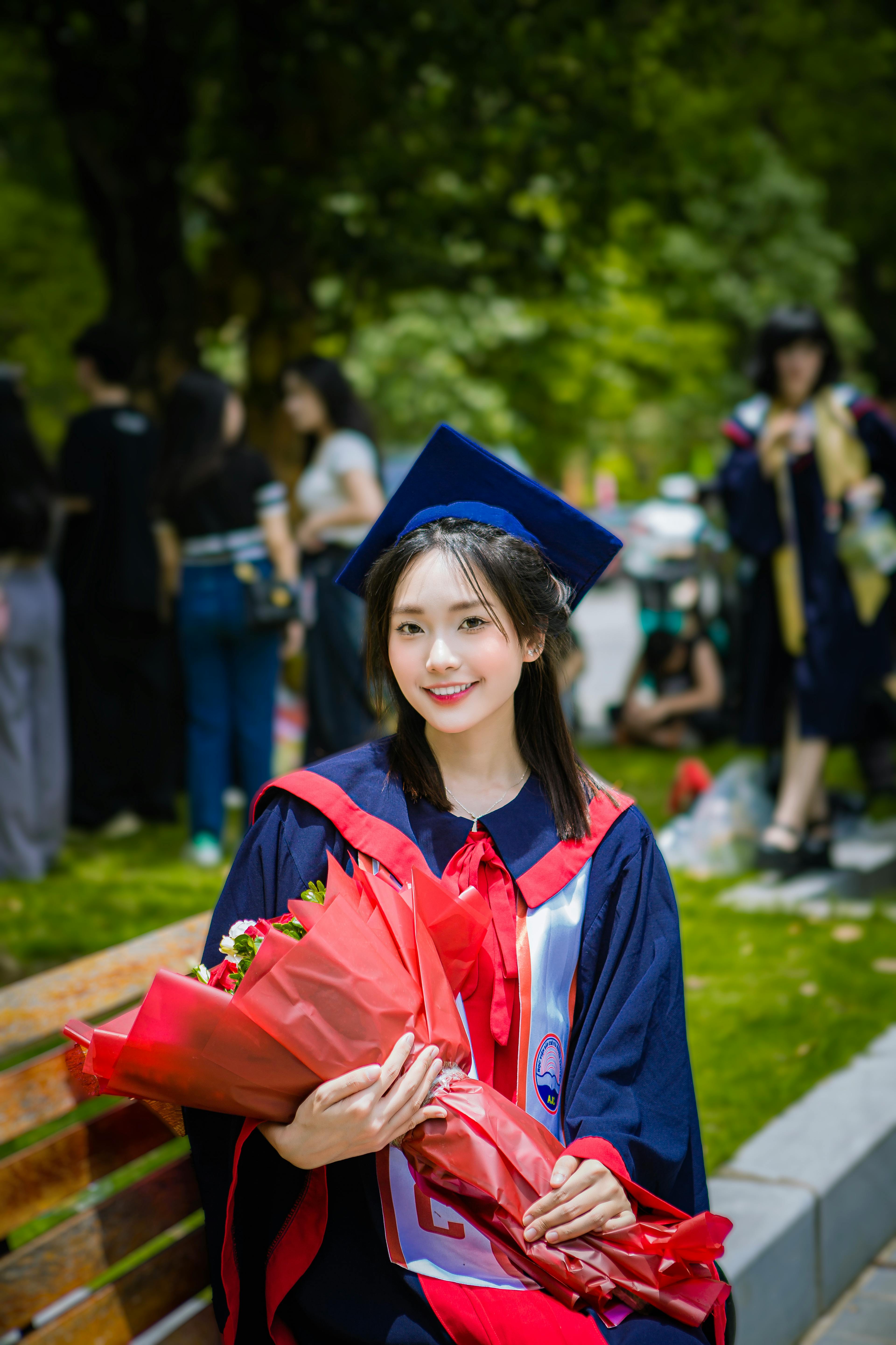 Cute Brunette Woman Posing on Bench After Graduation · Free Stock Photo