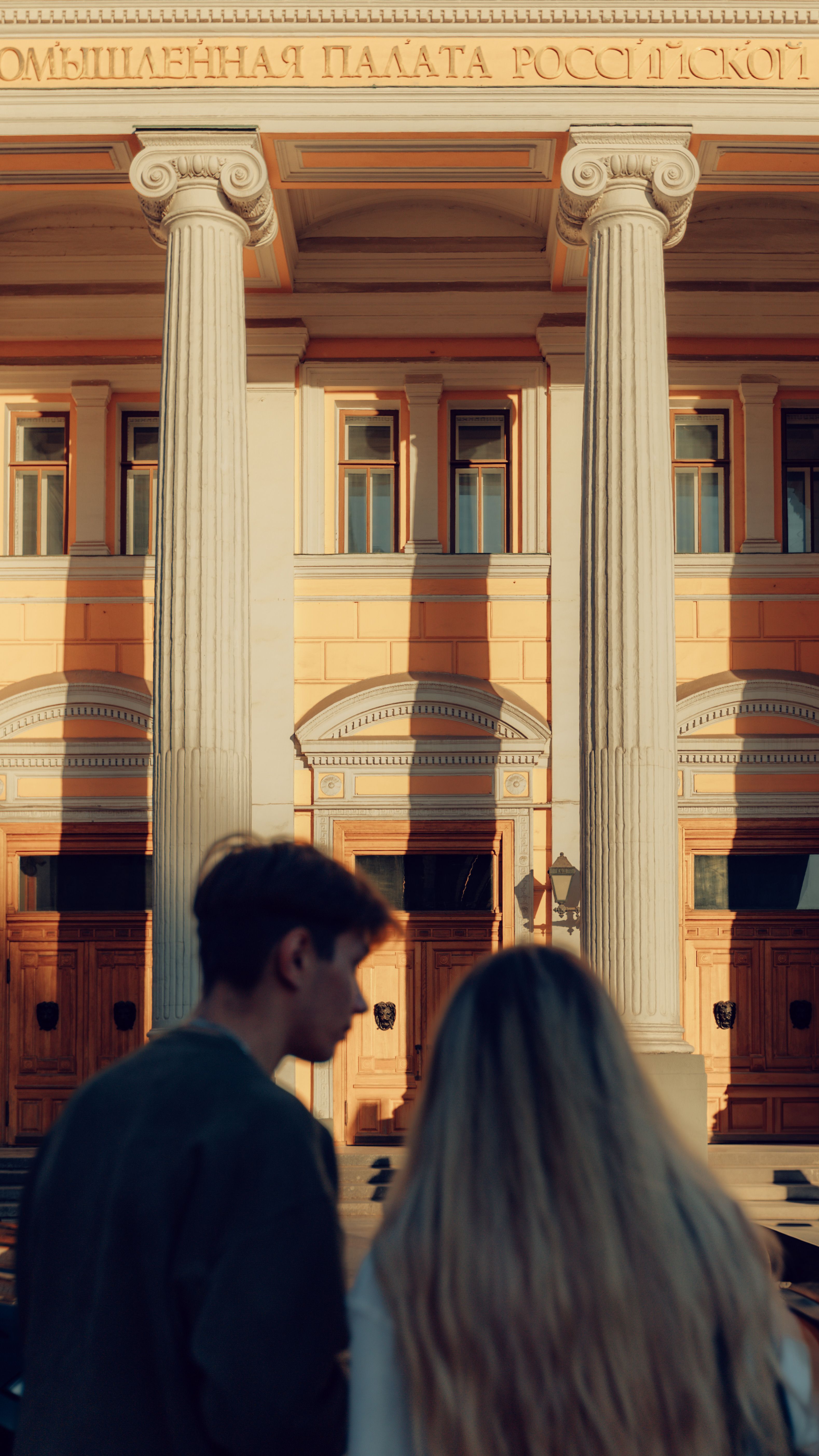 A couple standing in front of a building with columns · Free Stock Photo