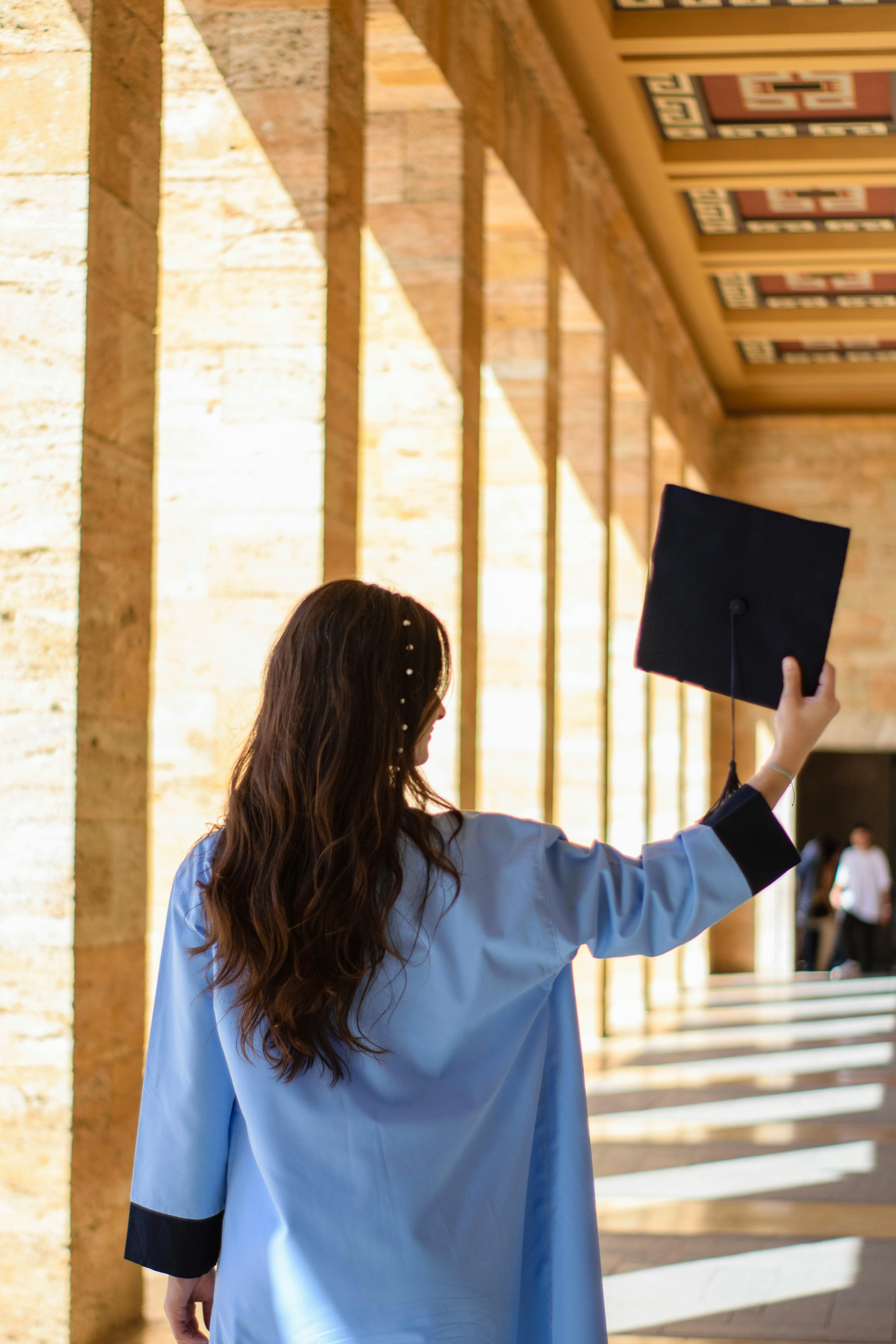 Woman Holding a Tablet Among Columns · Free Stock Photo