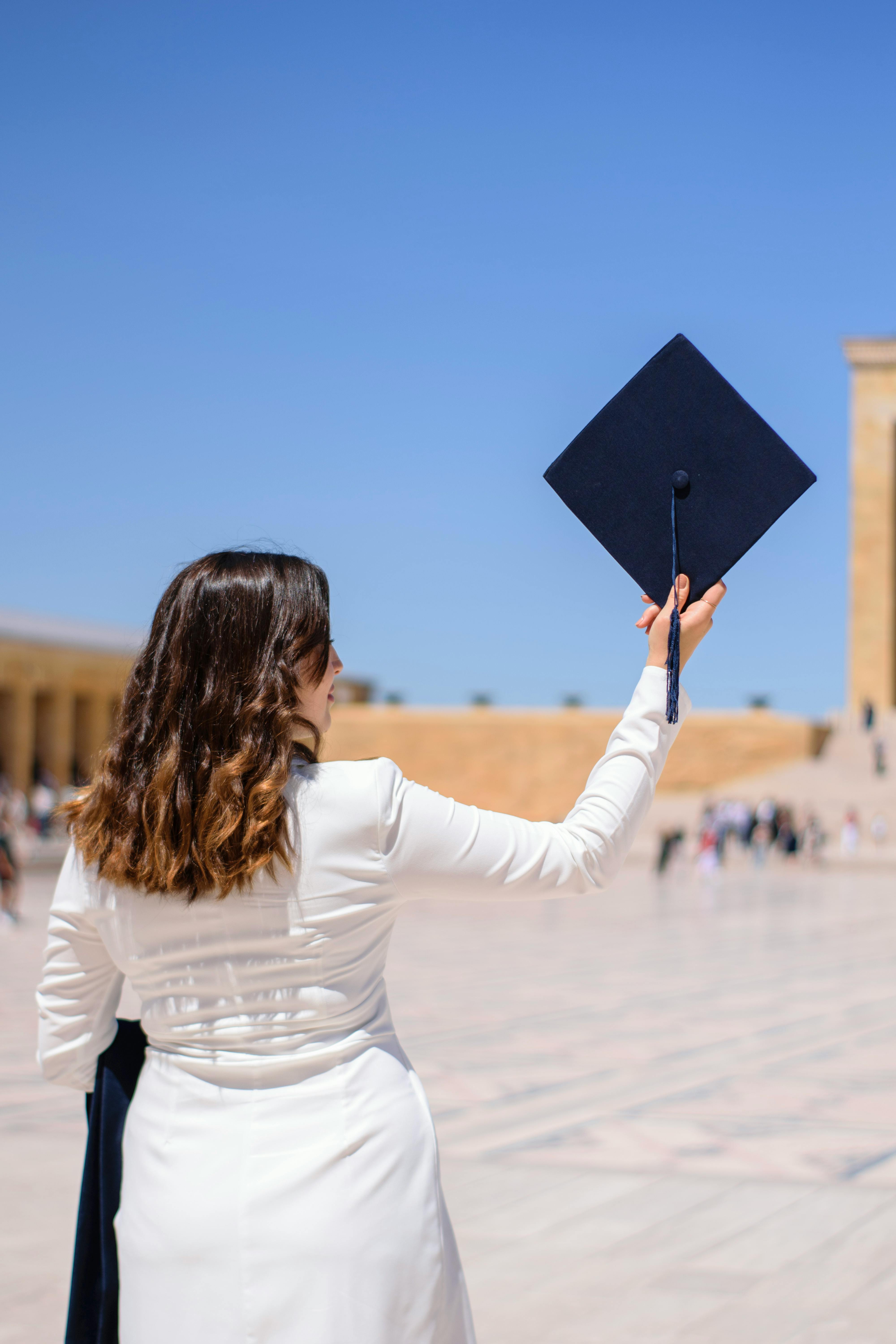 A Person Holding a Black Graduation Hat · Free Stock Photo