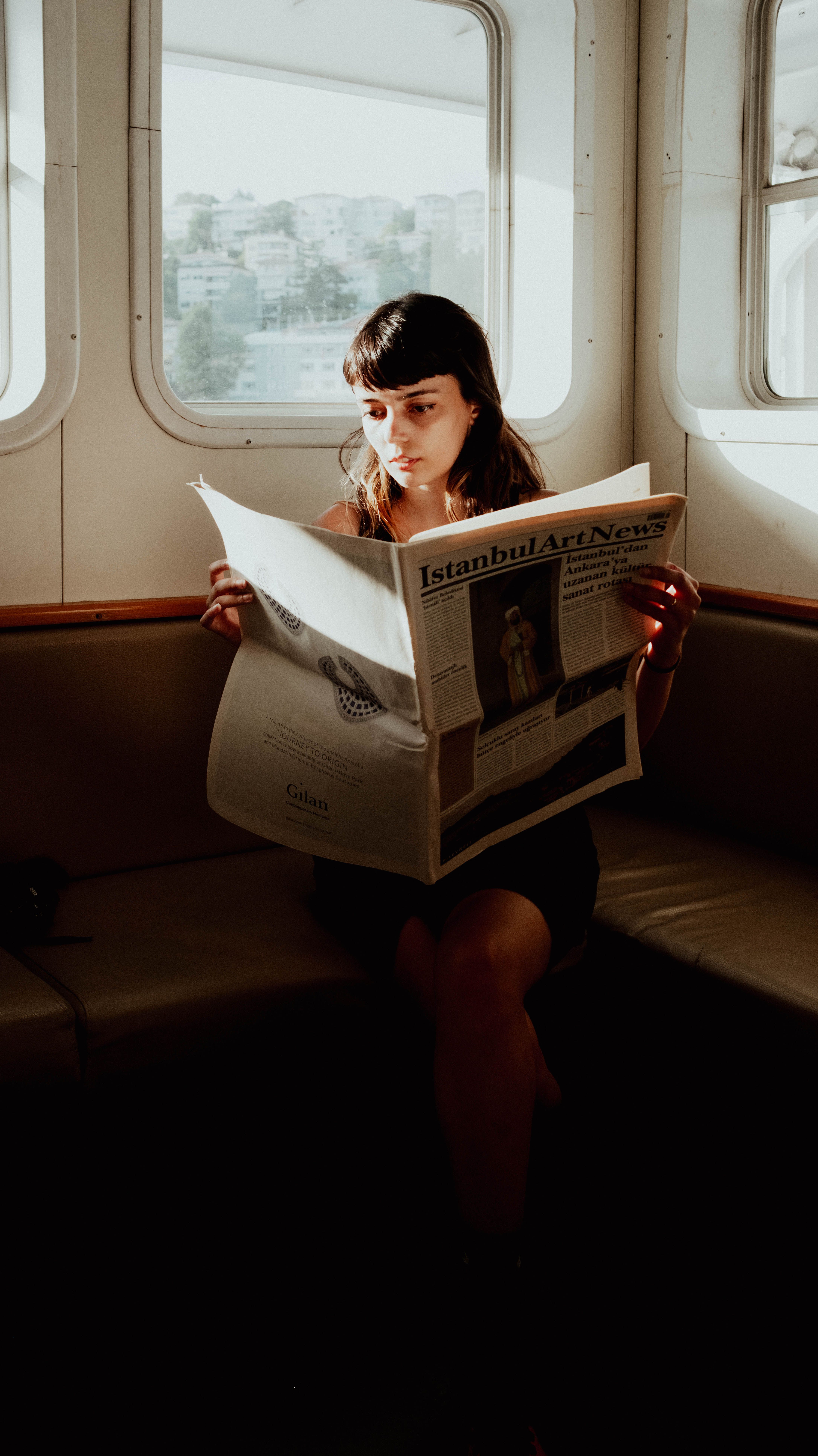 Woman Sitting and Reading Newspaper · Free Stock Photo