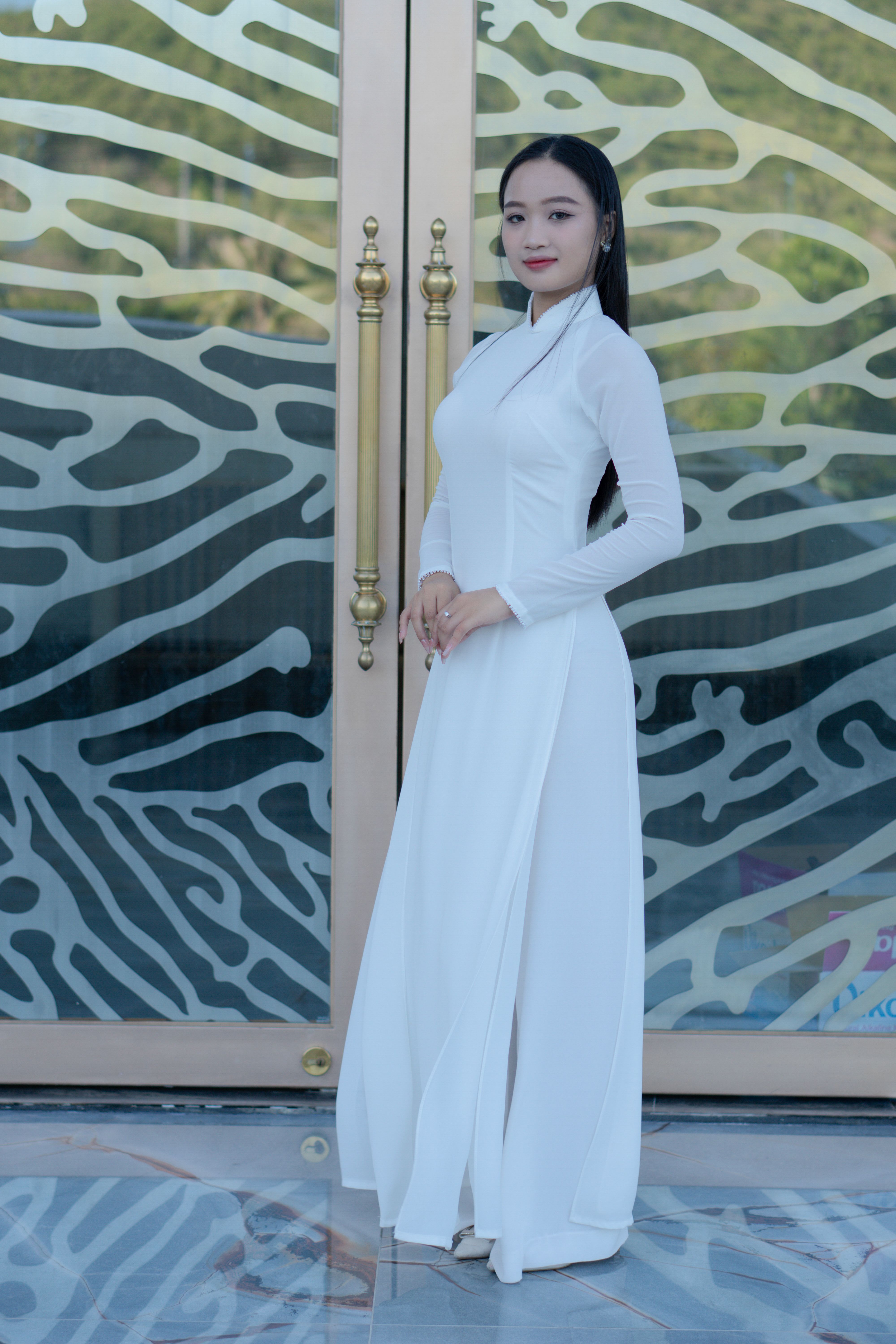 A Woman Wearing a White Ao Dai Standing in Fron of the Door · Free ...