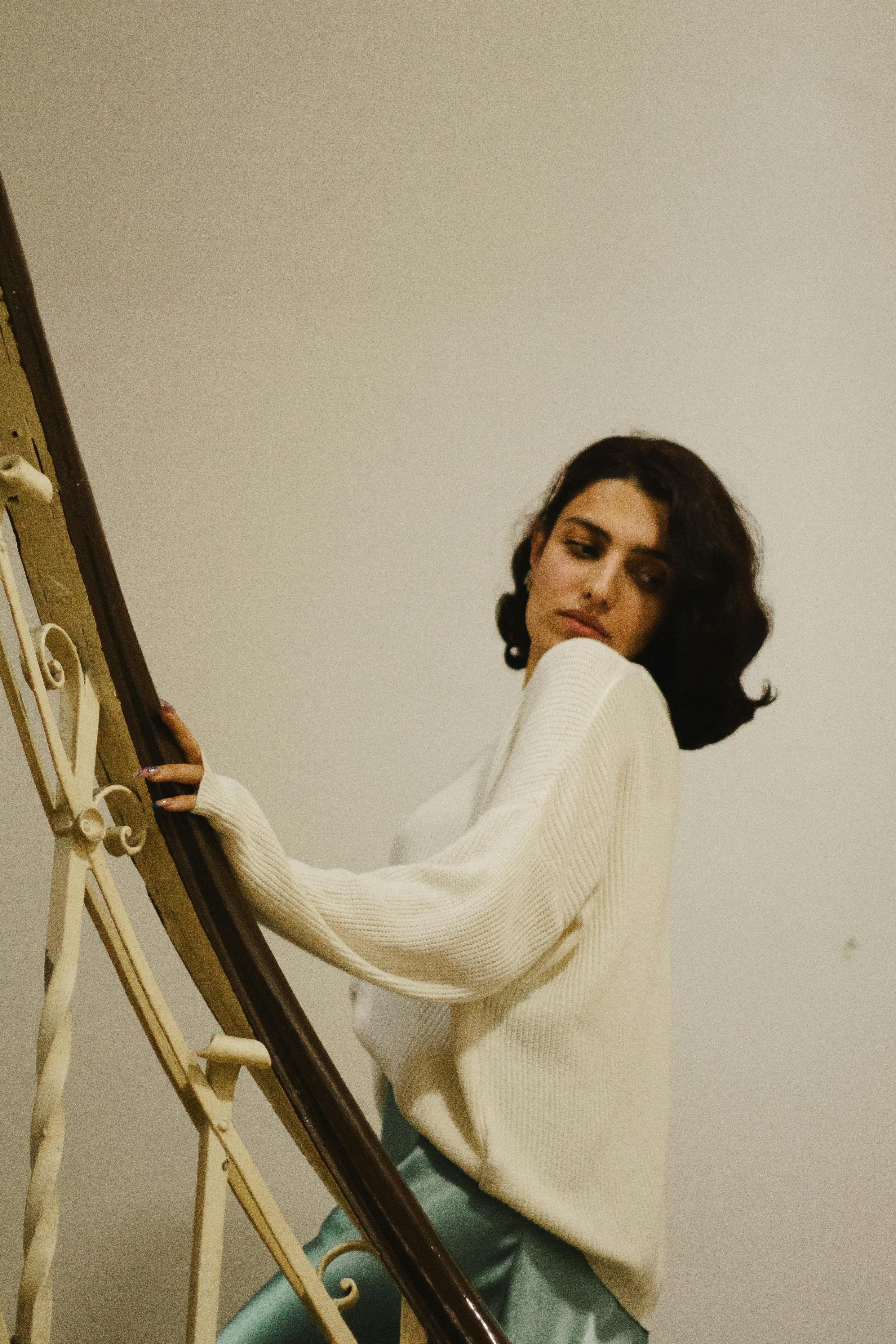 Woman Standing on Stairs with Hand on Railing · Free Stock Photo