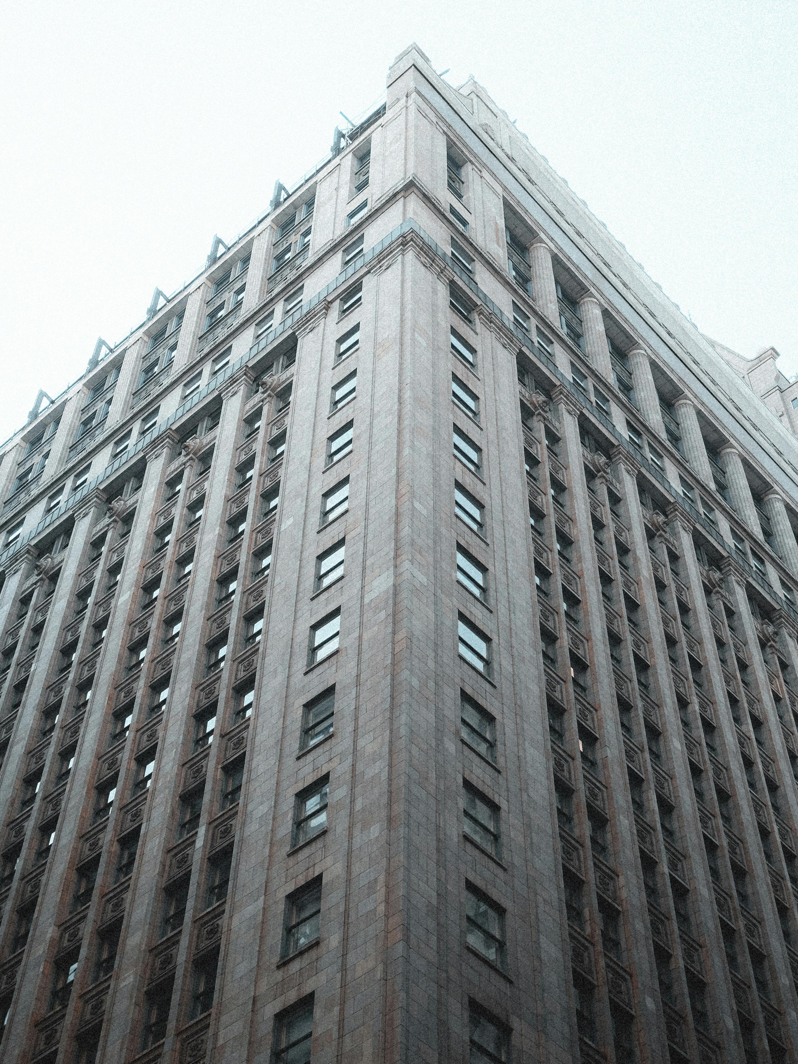 Corner of Tall Office Building with Columns on Top · Free Stock Photo