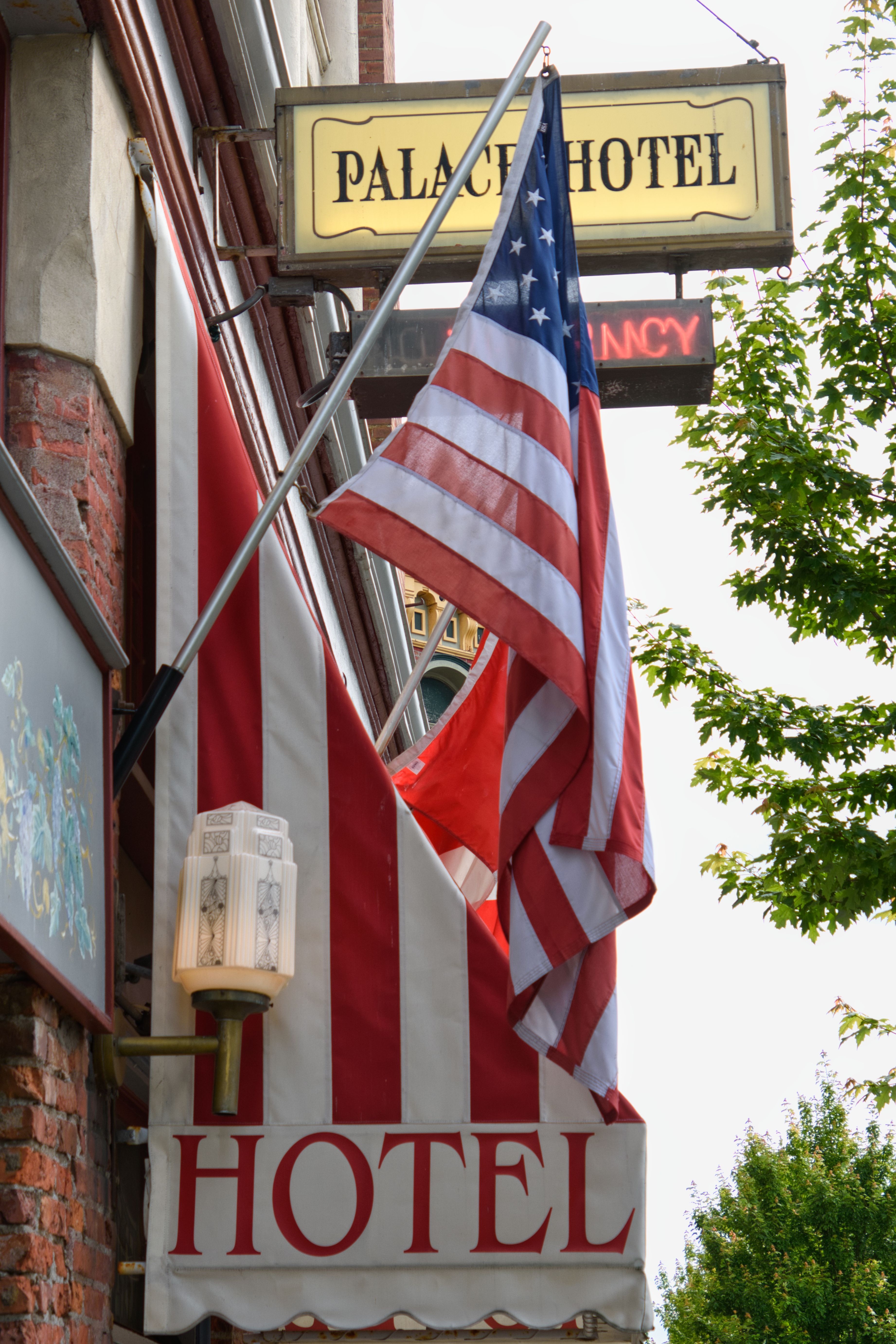American USA Flag Hanging over Hotel Front Entrance on Street · Free ...
