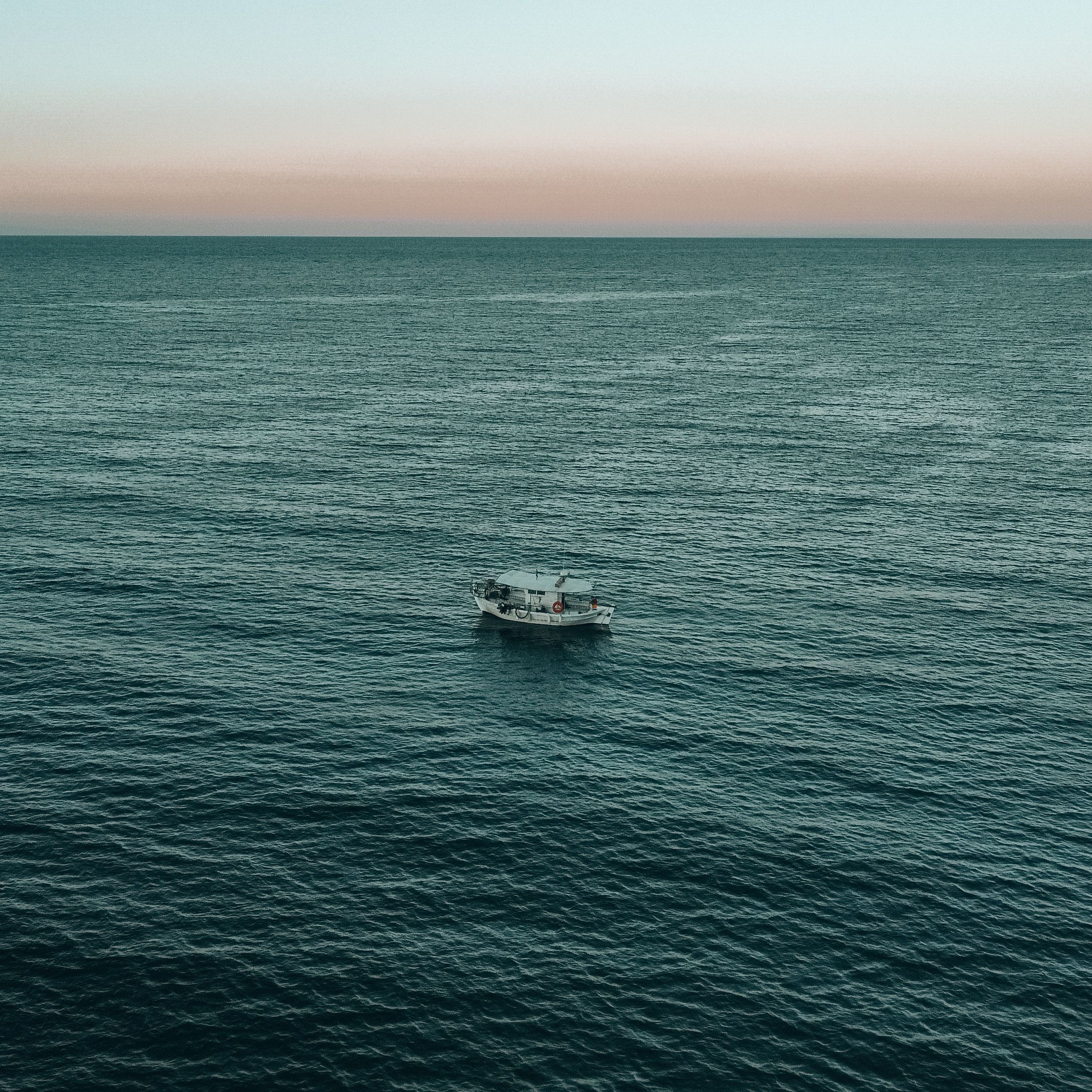Small Boat Sailing on Vast Sea · Free Stock Photo