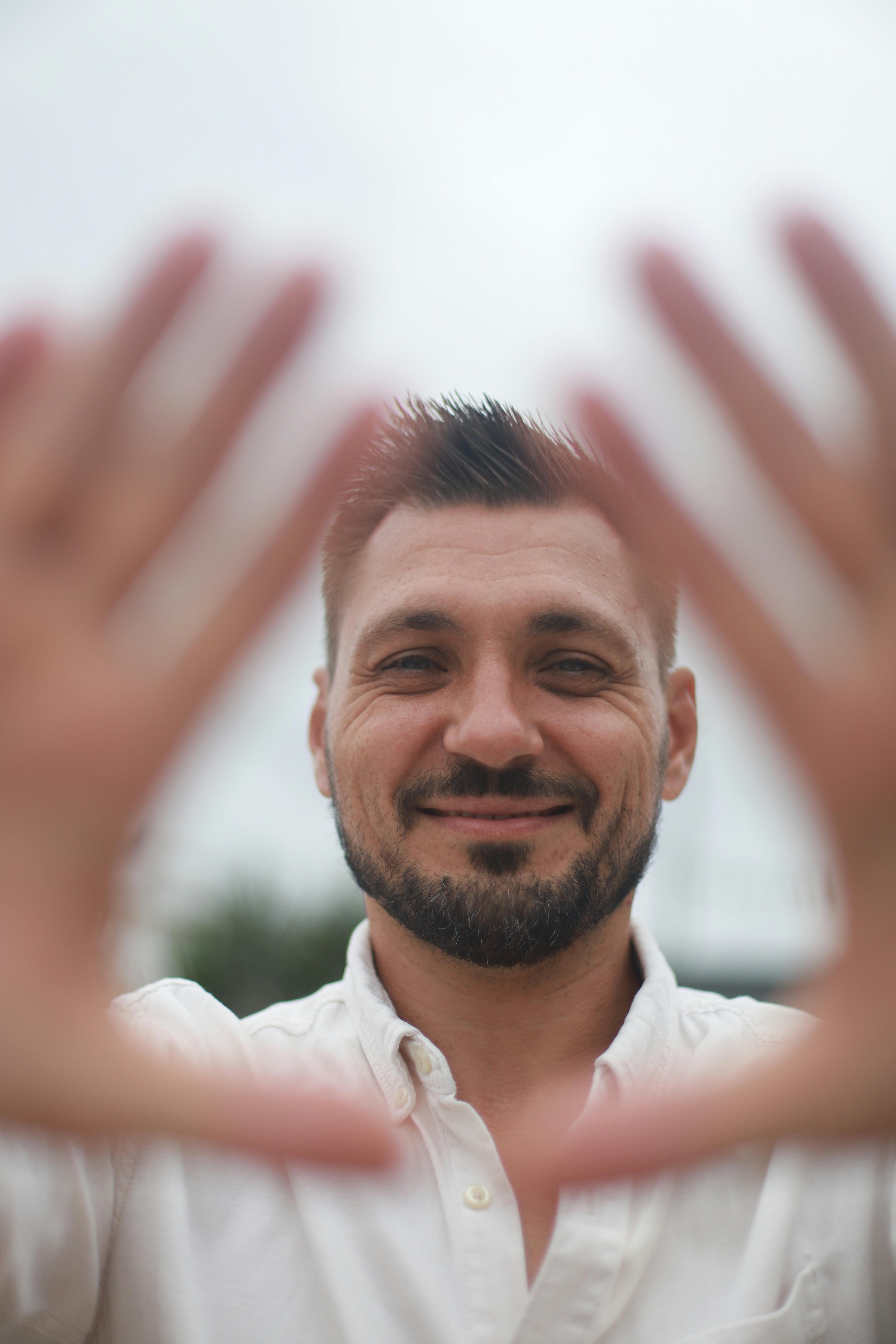 Portrait of a Smiling Man Reaching toward the Camera · Free Stock Photo