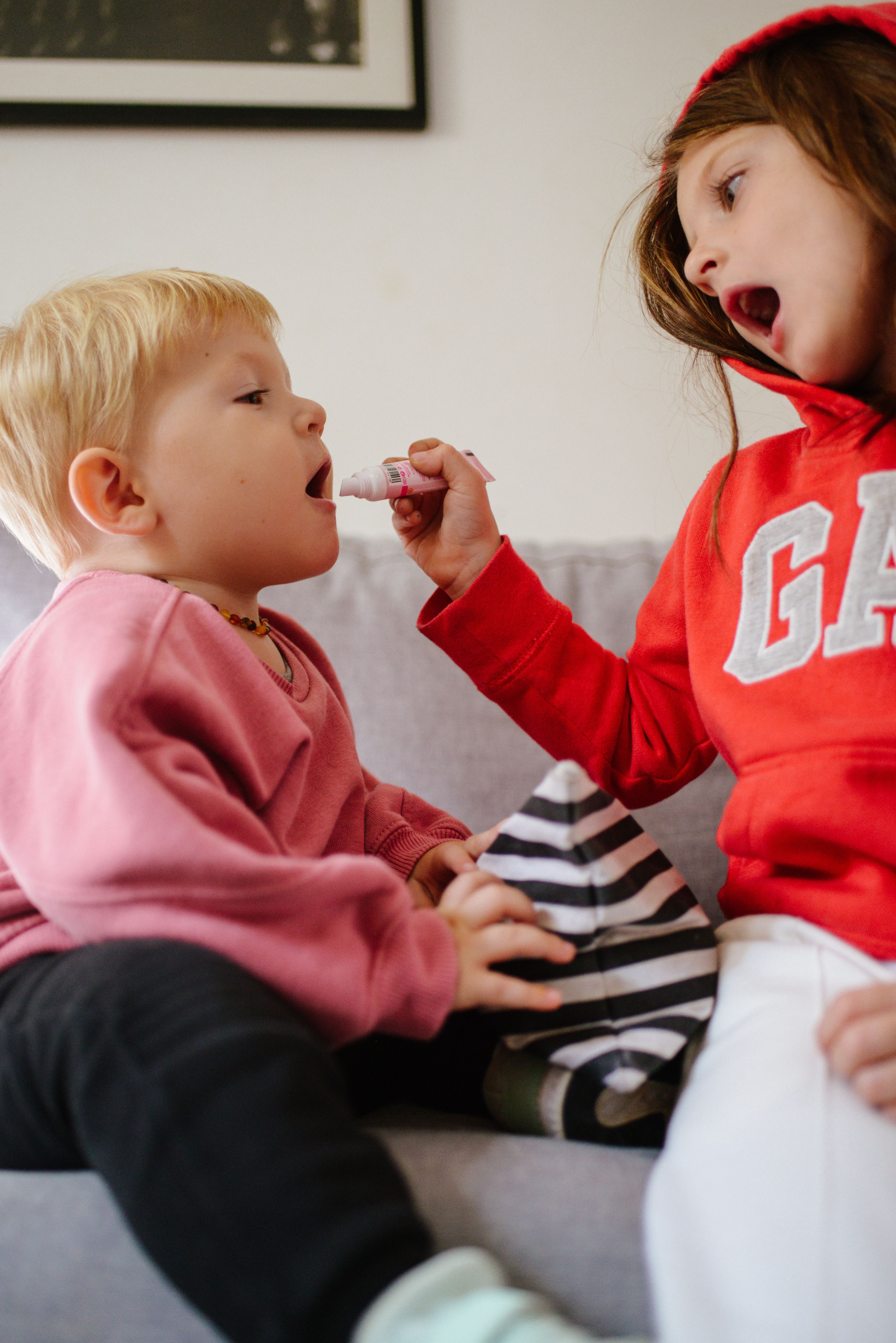A Girl Putting Lipstick on the Lips of Her Little Sister · Free Stock Photo