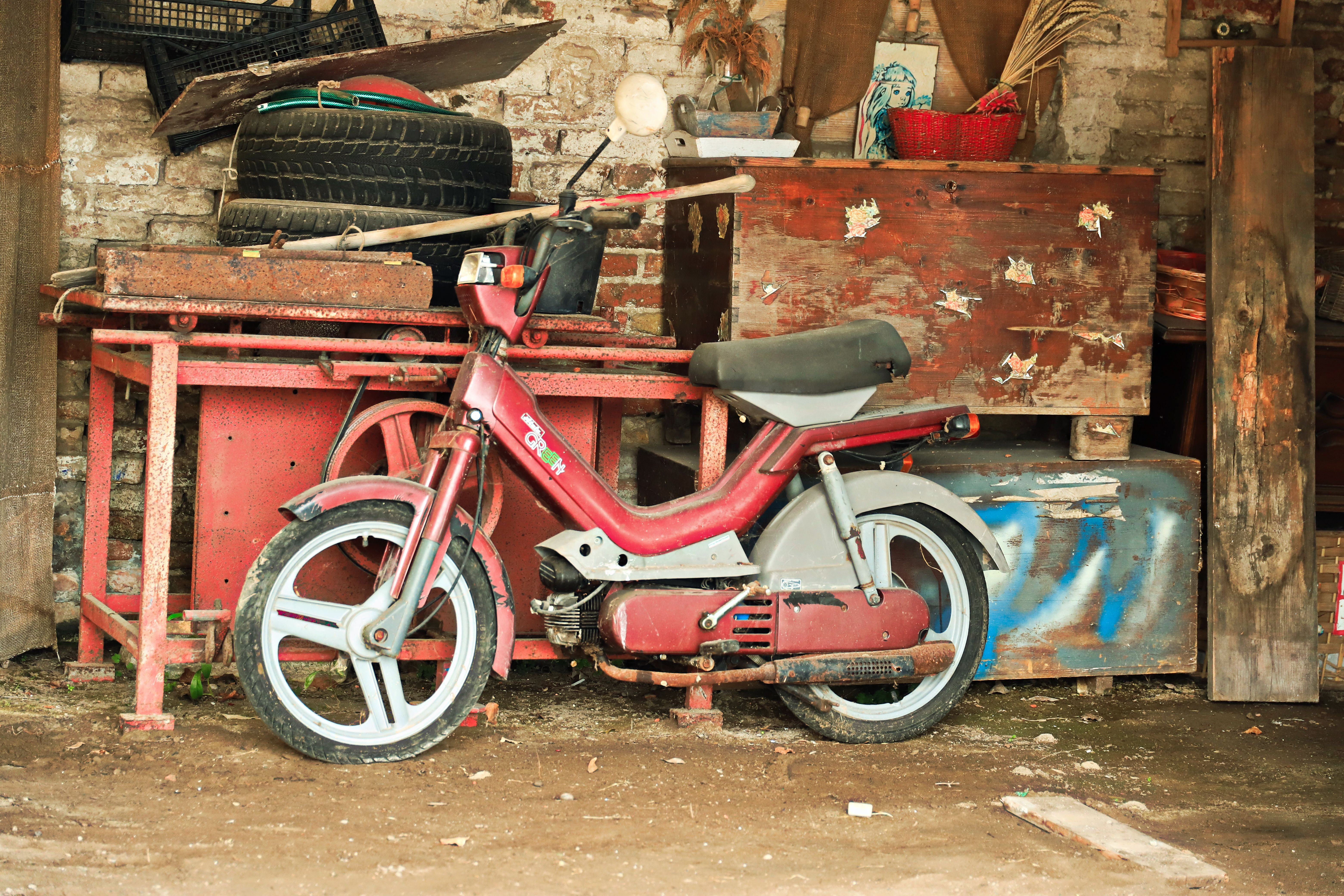 An Old Motor Scooter Standing in a Garage · Free Stock Photo