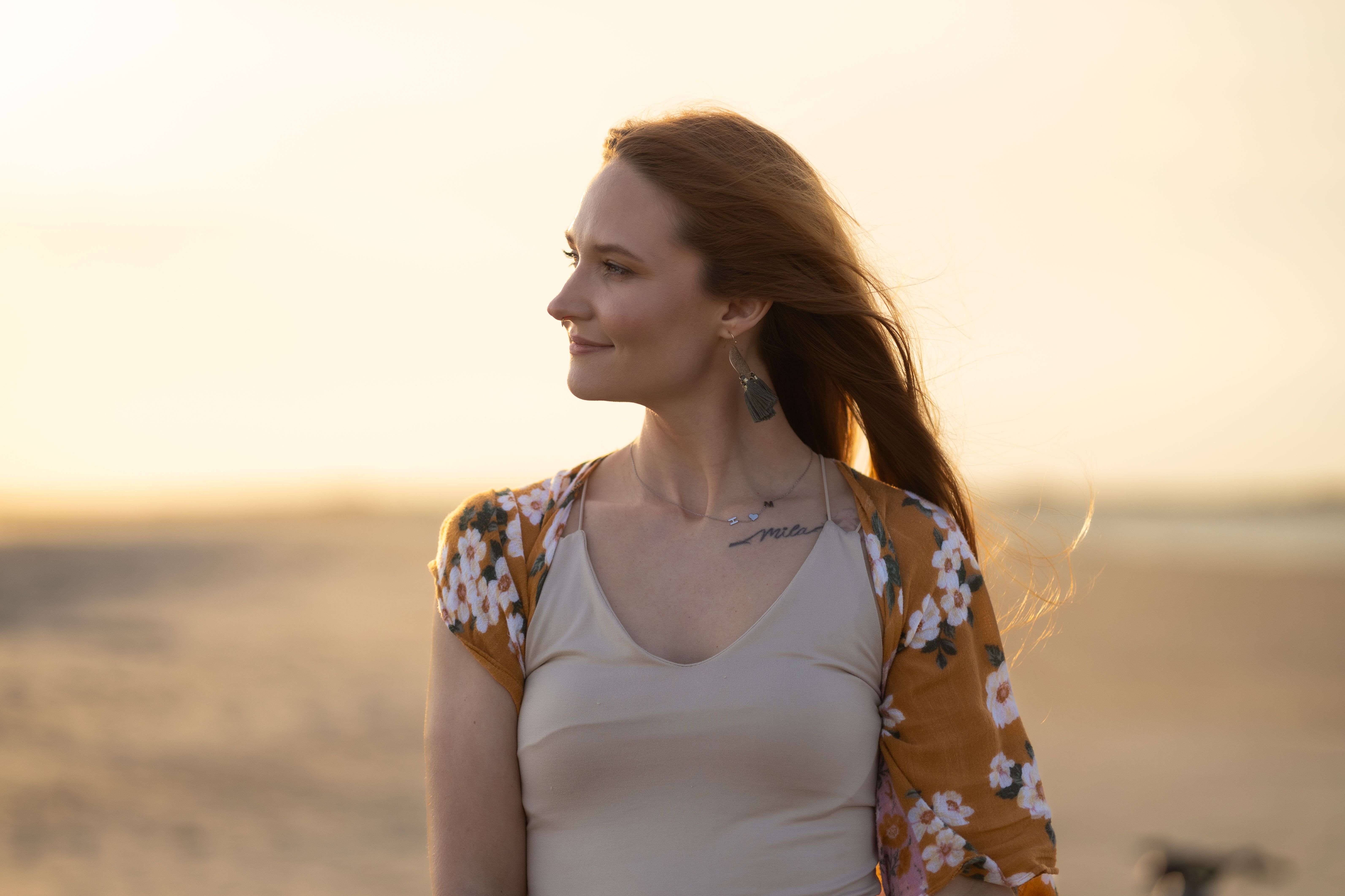 A Young Woman Standing Outside at Sunset · Free Stock Photo