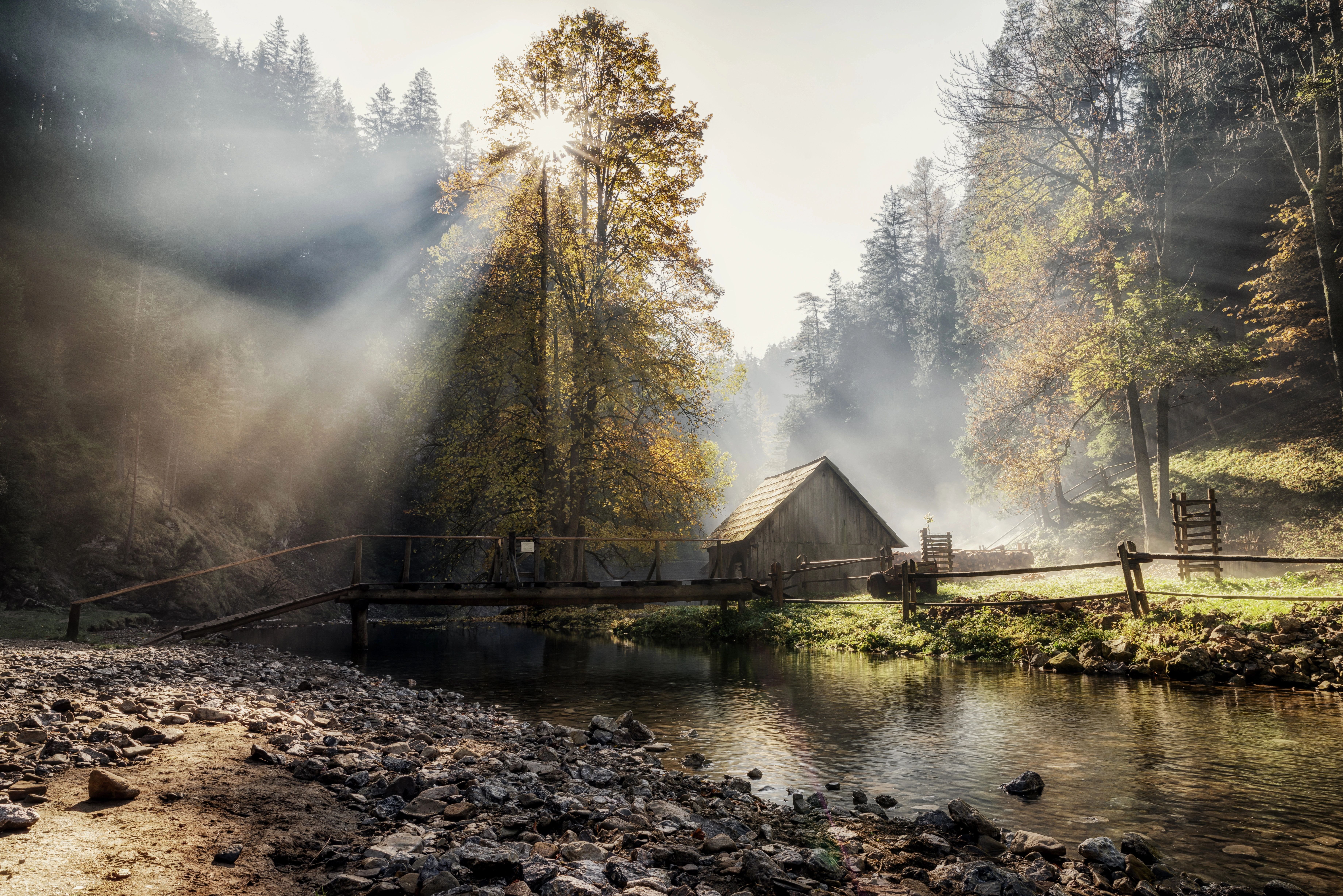 Sunset Sunlight over River and Wooden House in Valley · Free Stock Photo