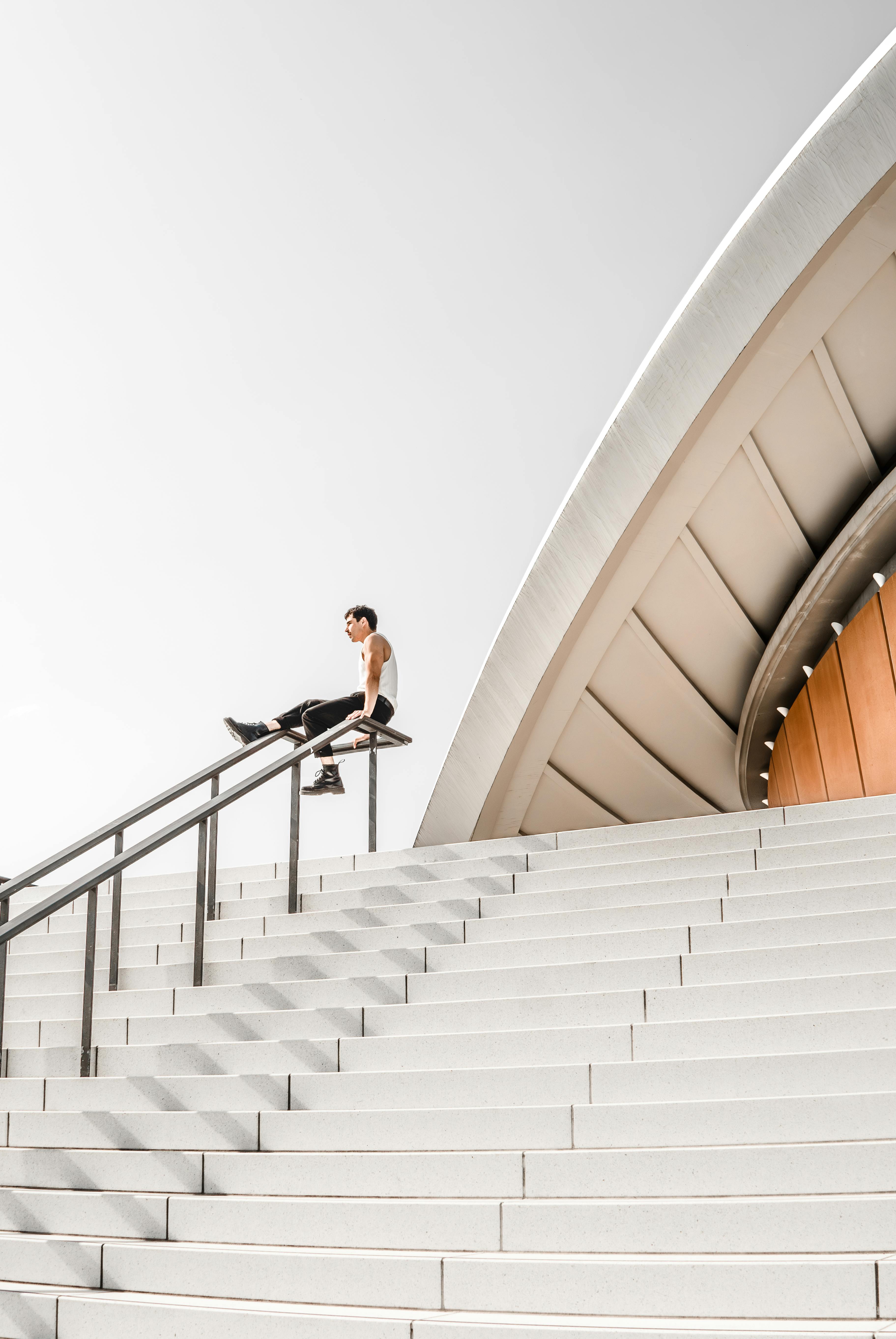 Man Sitting on Stairs Handrails · Free Stock Photo