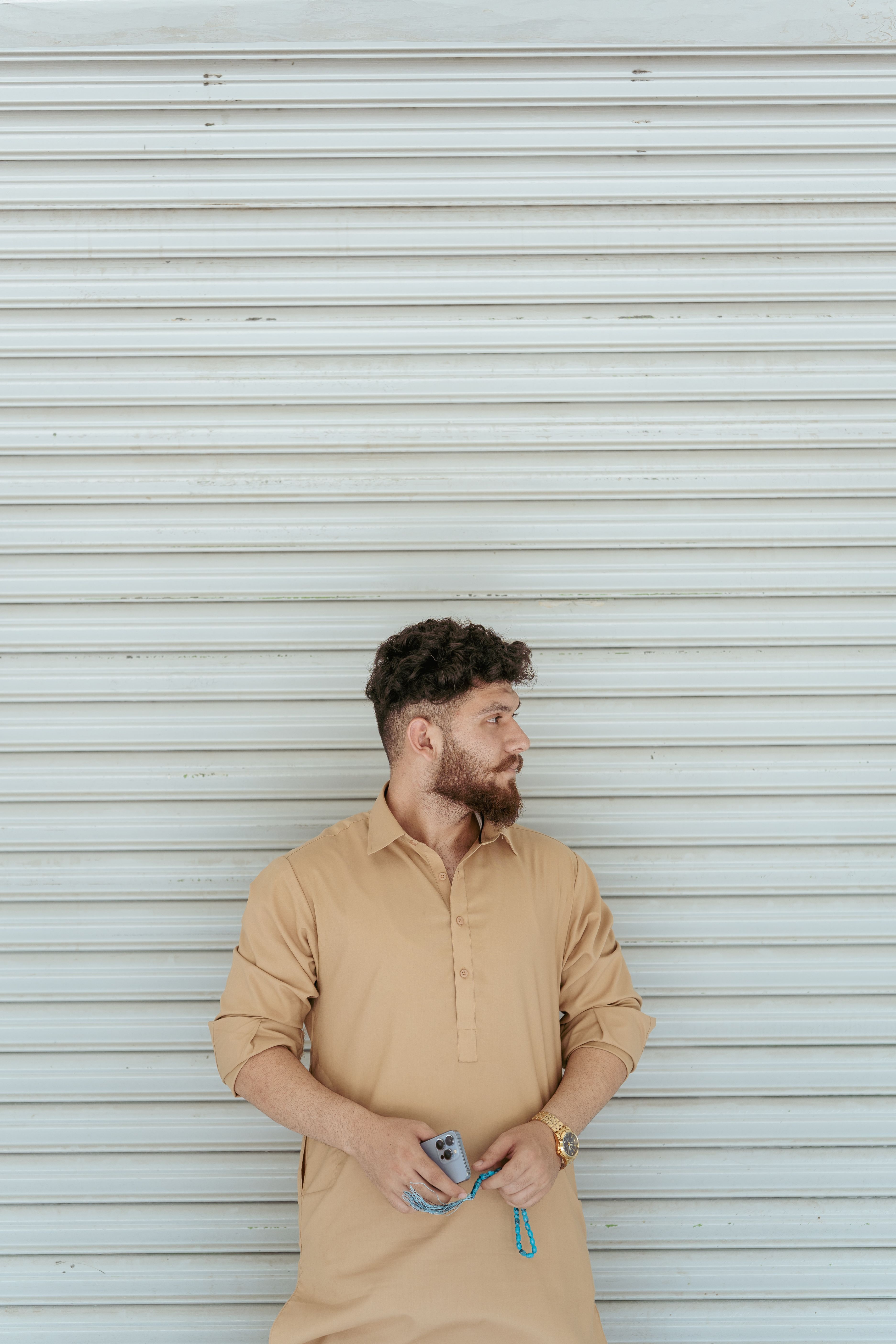 A Bearded Man Posing in a Brown Outfit · Free Stock Photo
