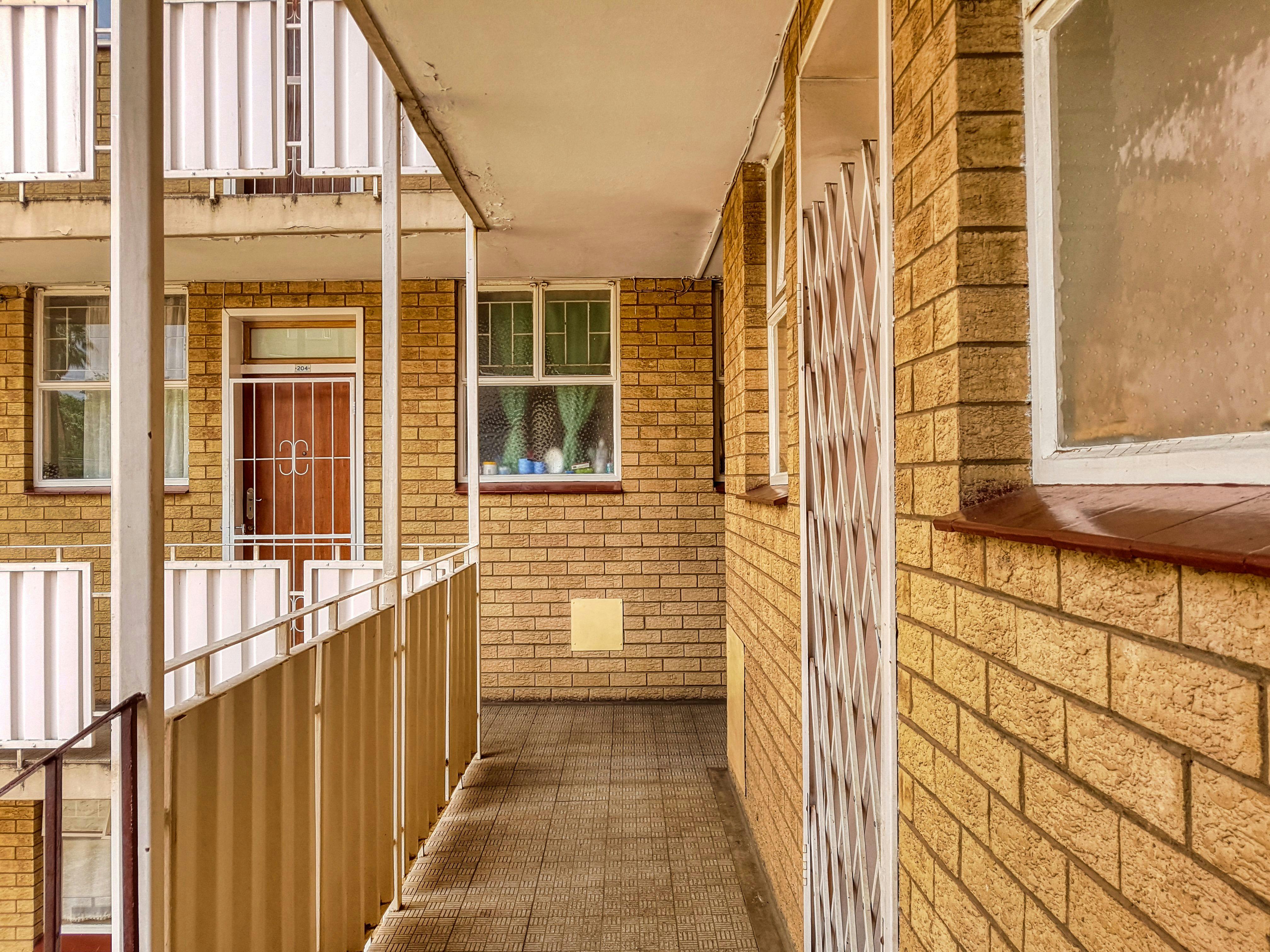 A balcony with a door and a balcony railing · Free Stock Photo