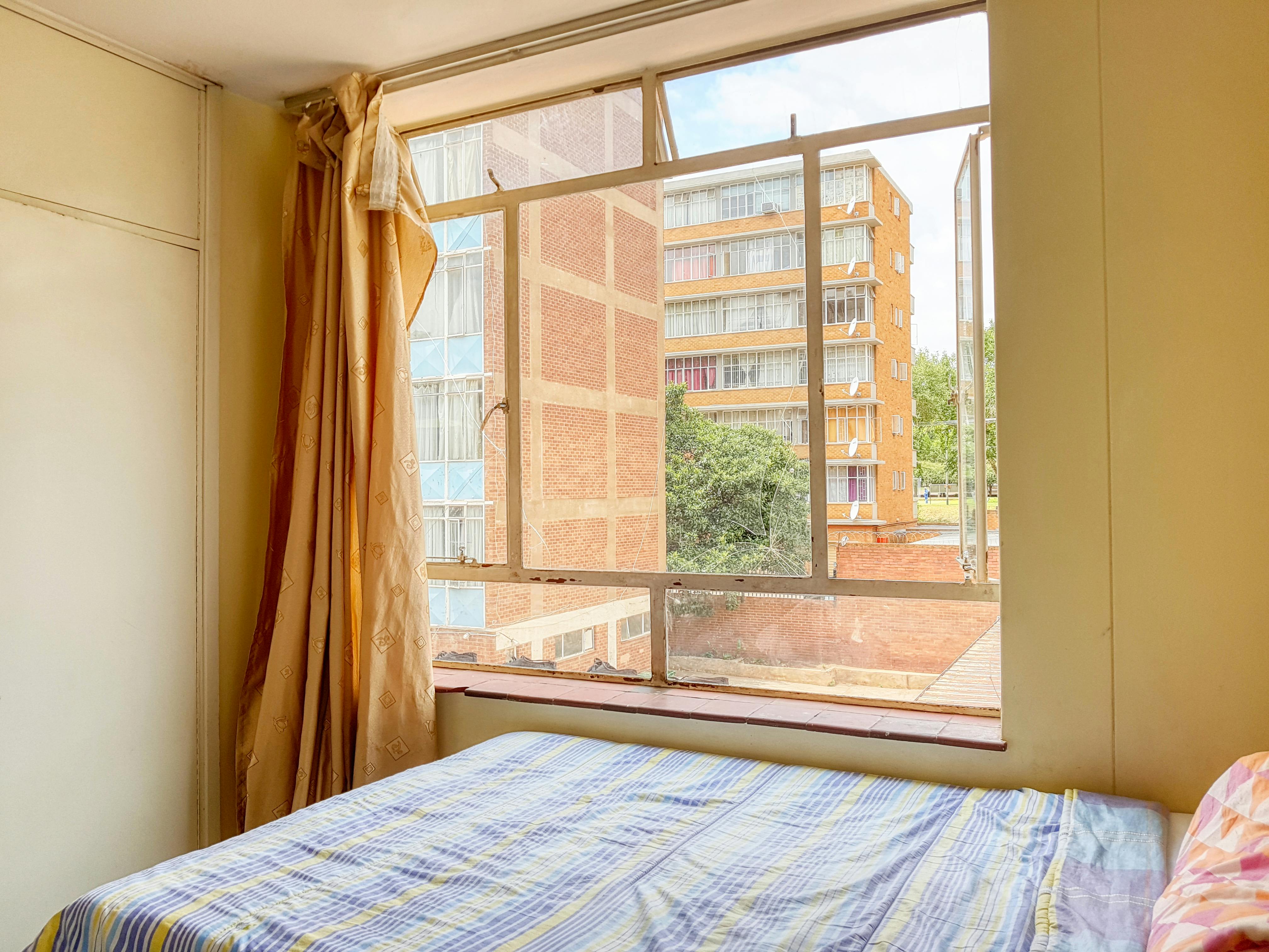 A bedroom with a bed and a window with a view · Free Stock Photo