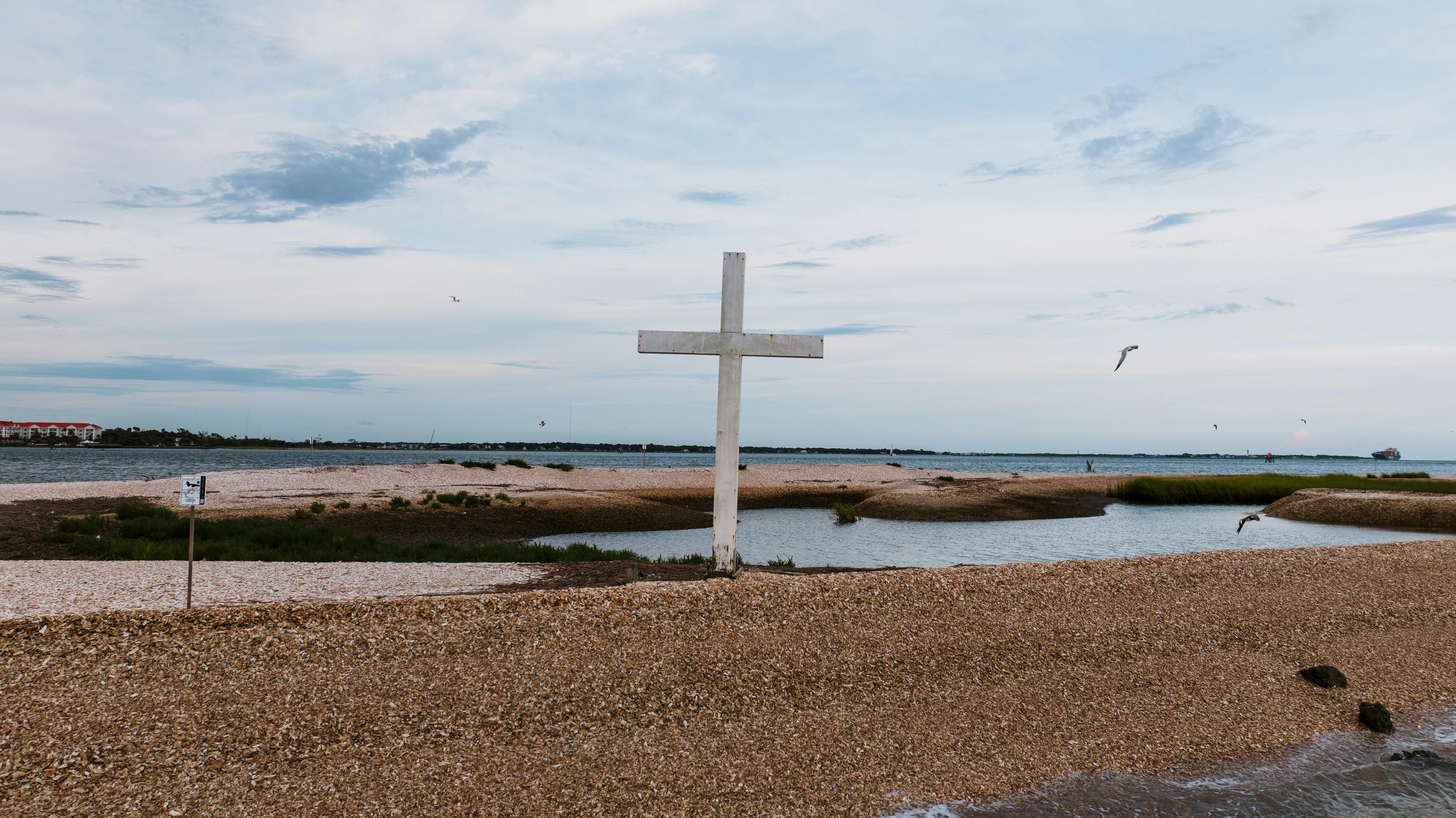 Cross on the beach at the end of a pier · Free Stock Photo