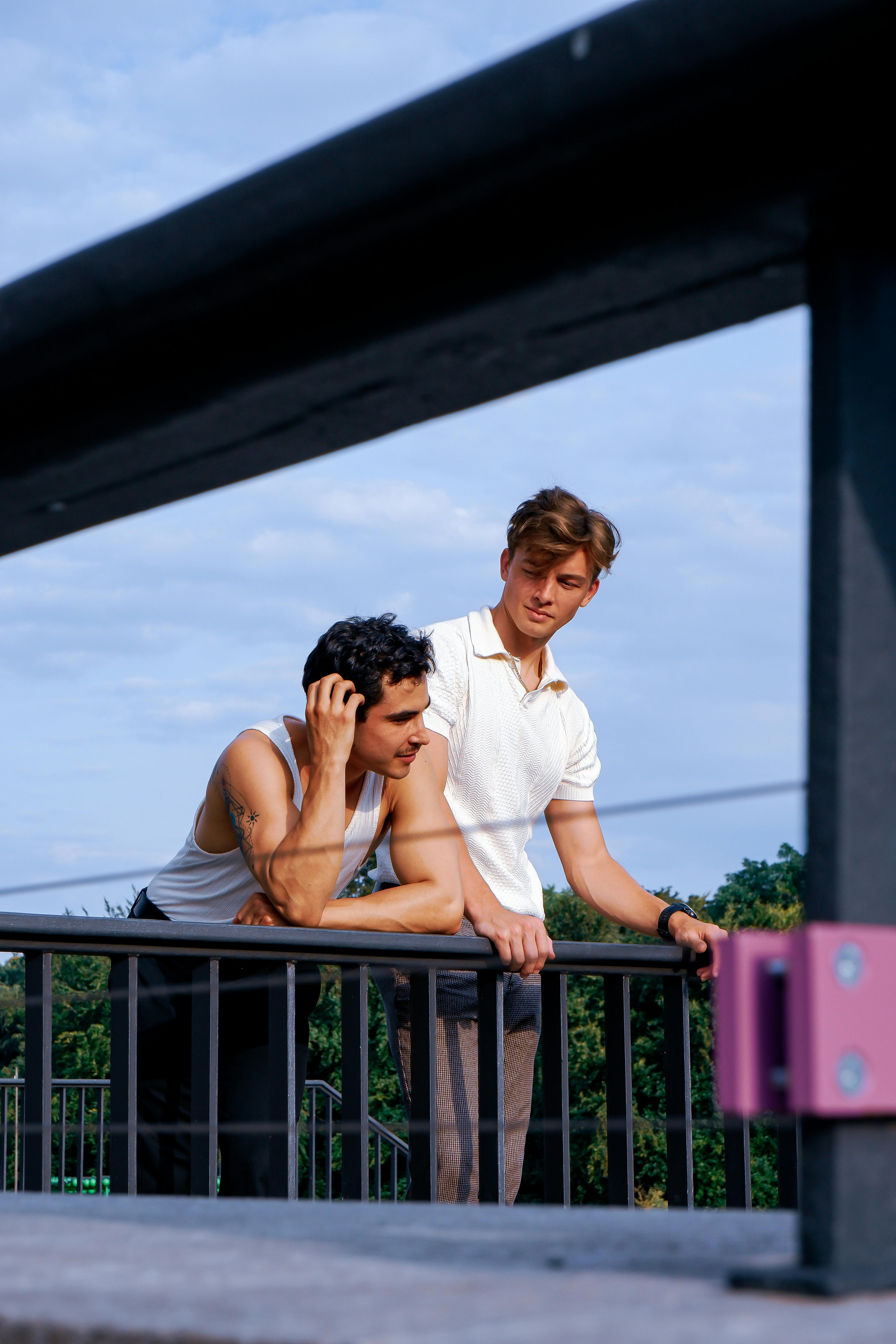 Two Men Standing by a Railing · Free Stock Photo