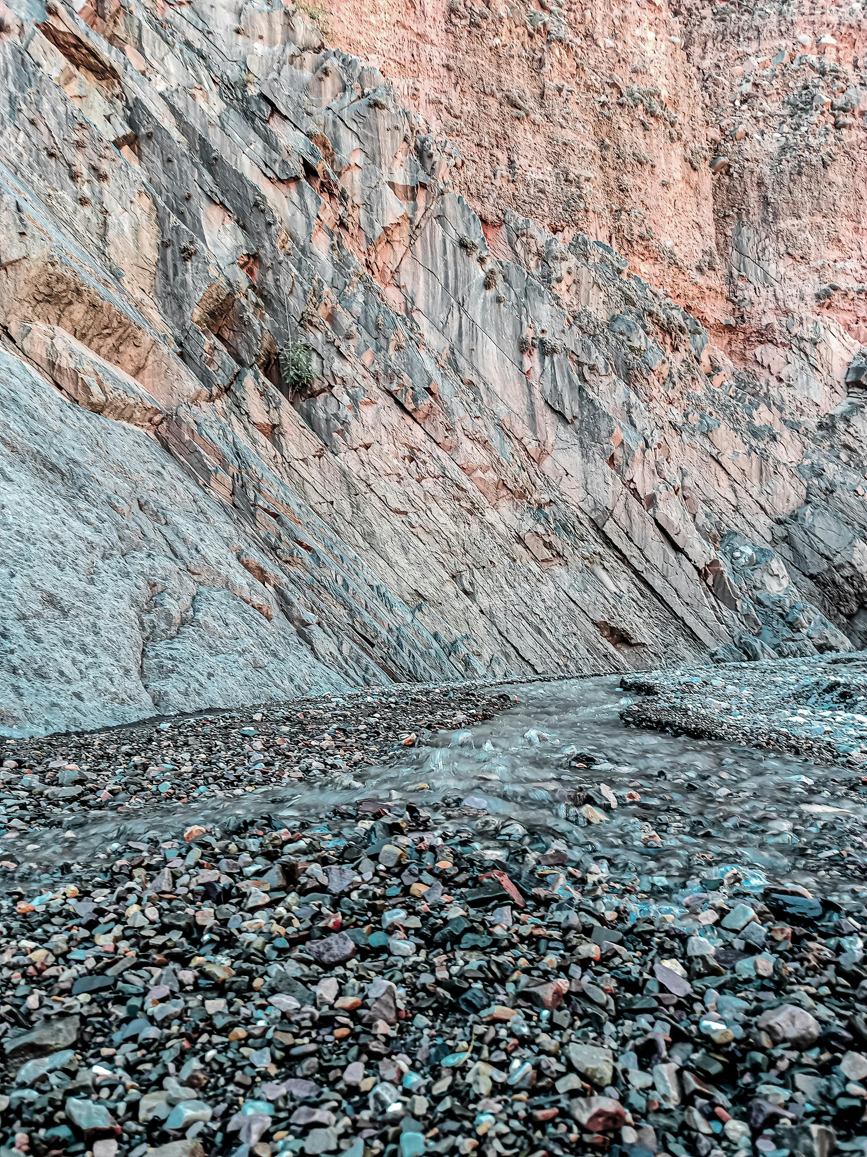 A person walking on a rocky path near a cliff · Free Stock Photo