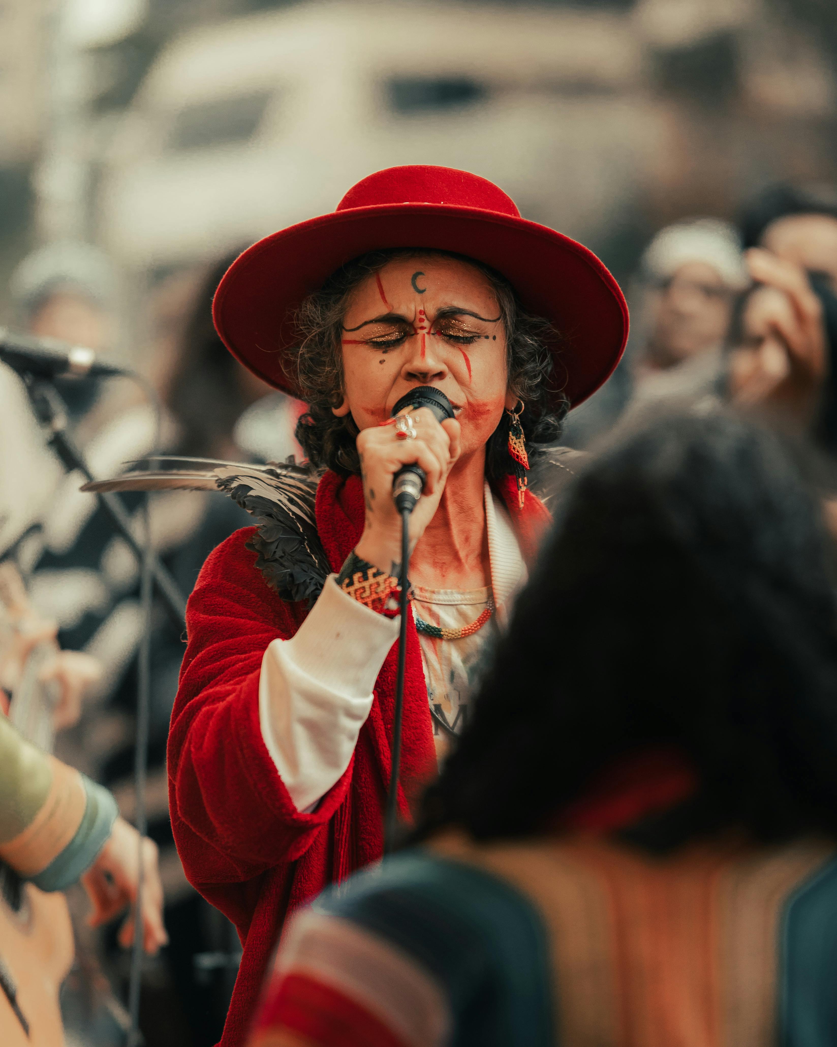 Woman in Red Hat Costume and Artistic Makeup Singing into Microphone ...