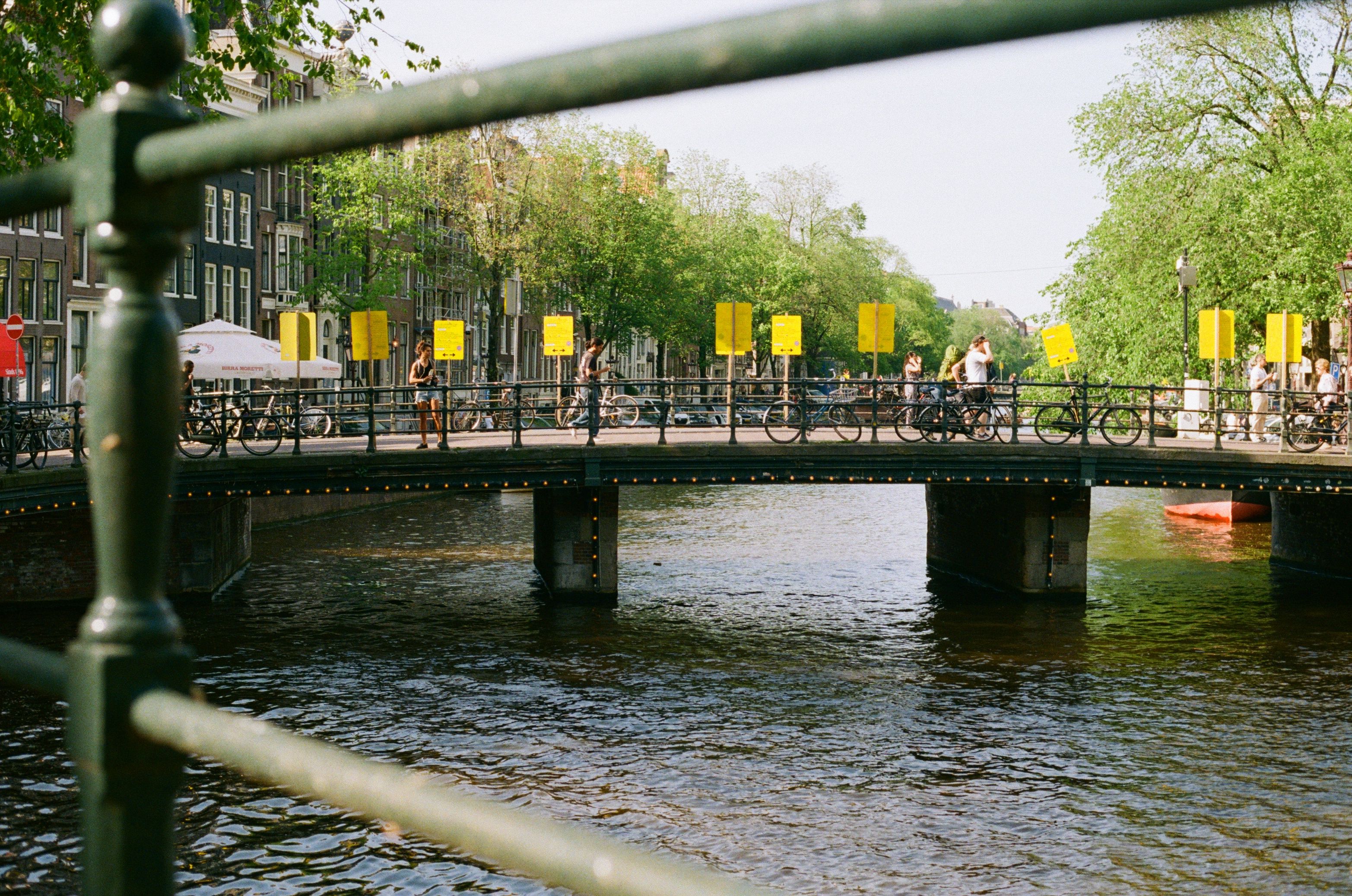 A bridge over a river with yellow signs on it · Free Stock Photo