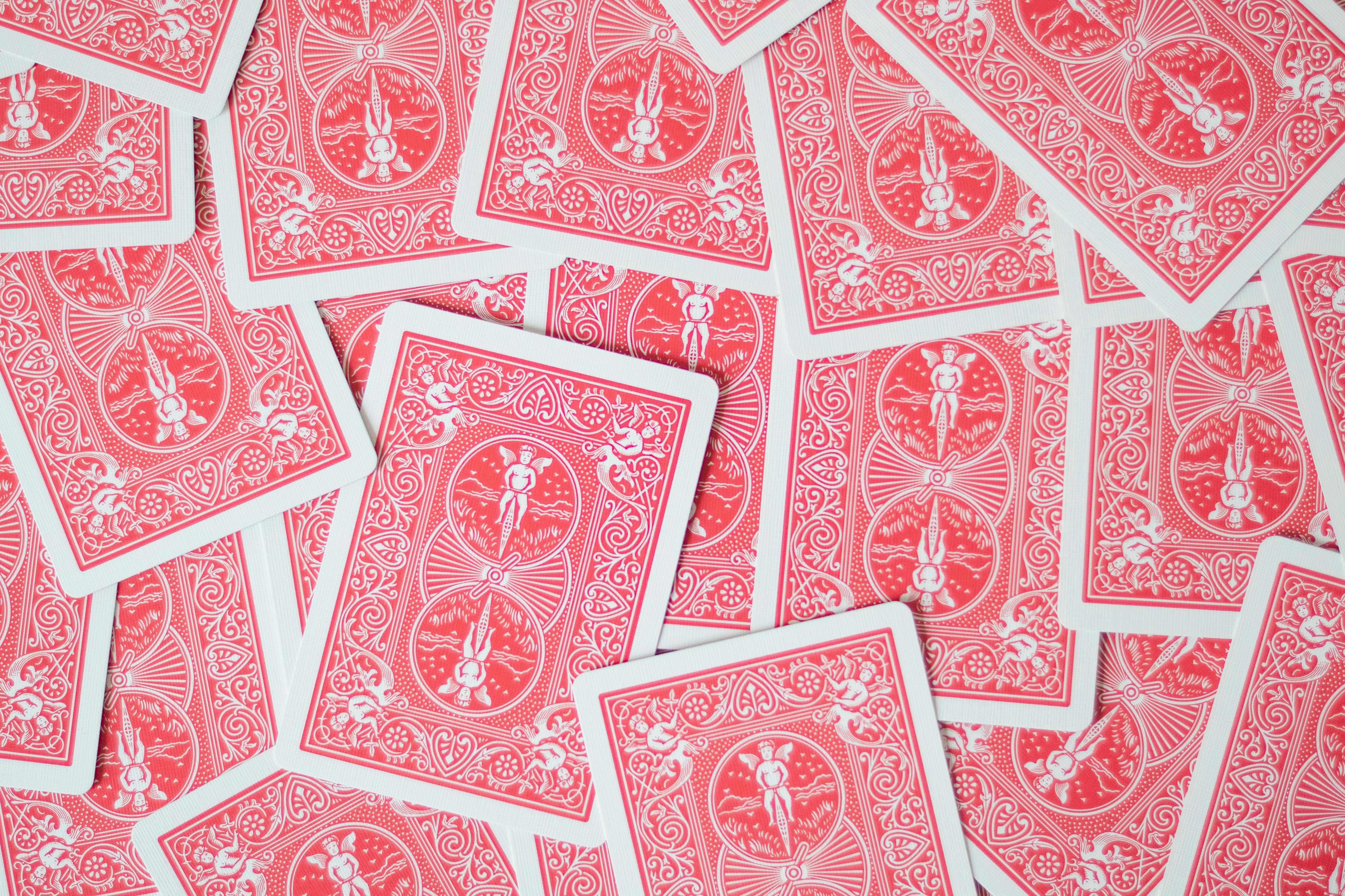 A pile of playing cards with red and white designs · Free Stock Photo