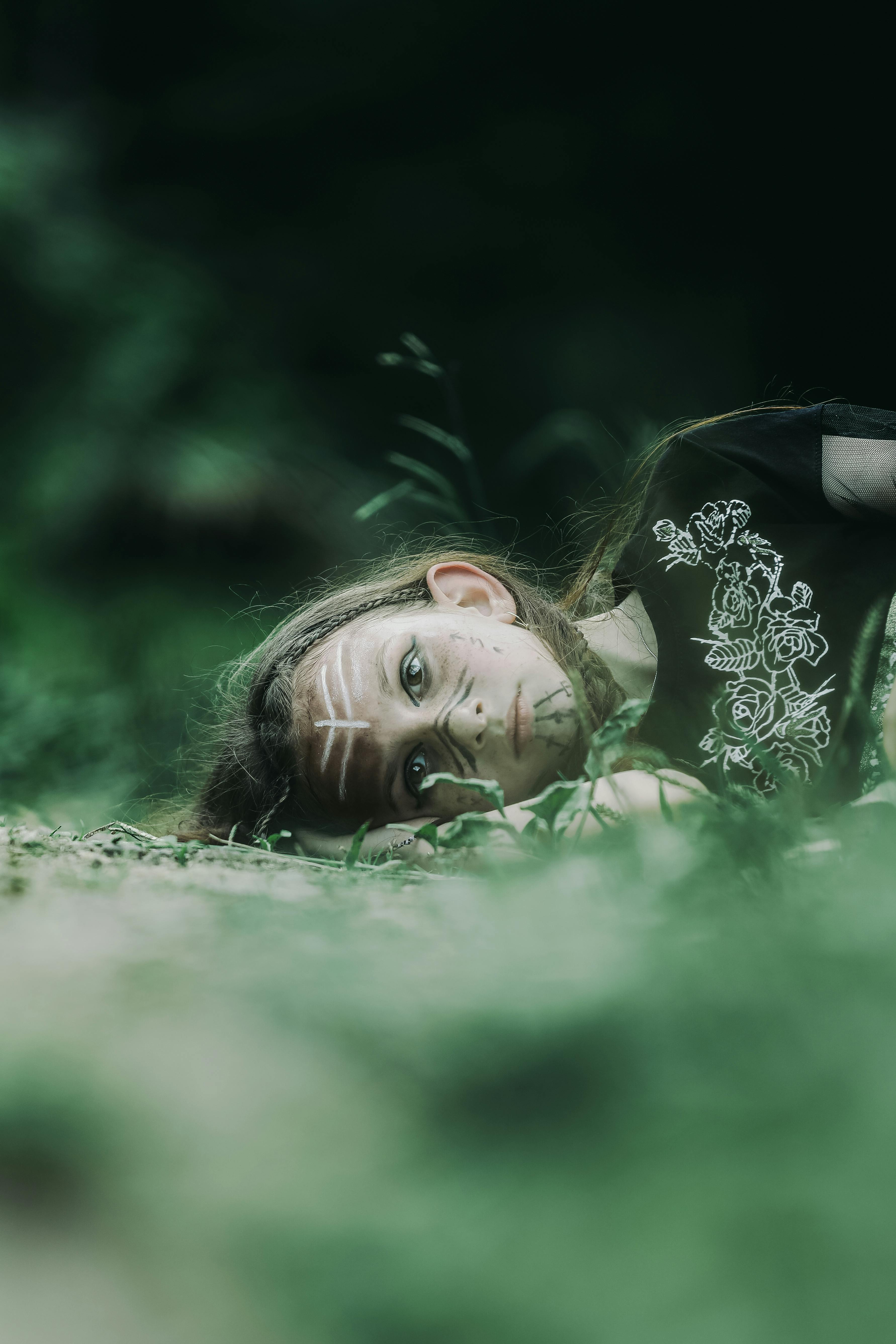 Girl with Painted Face Lying Down on Ground · Free Stock Photo