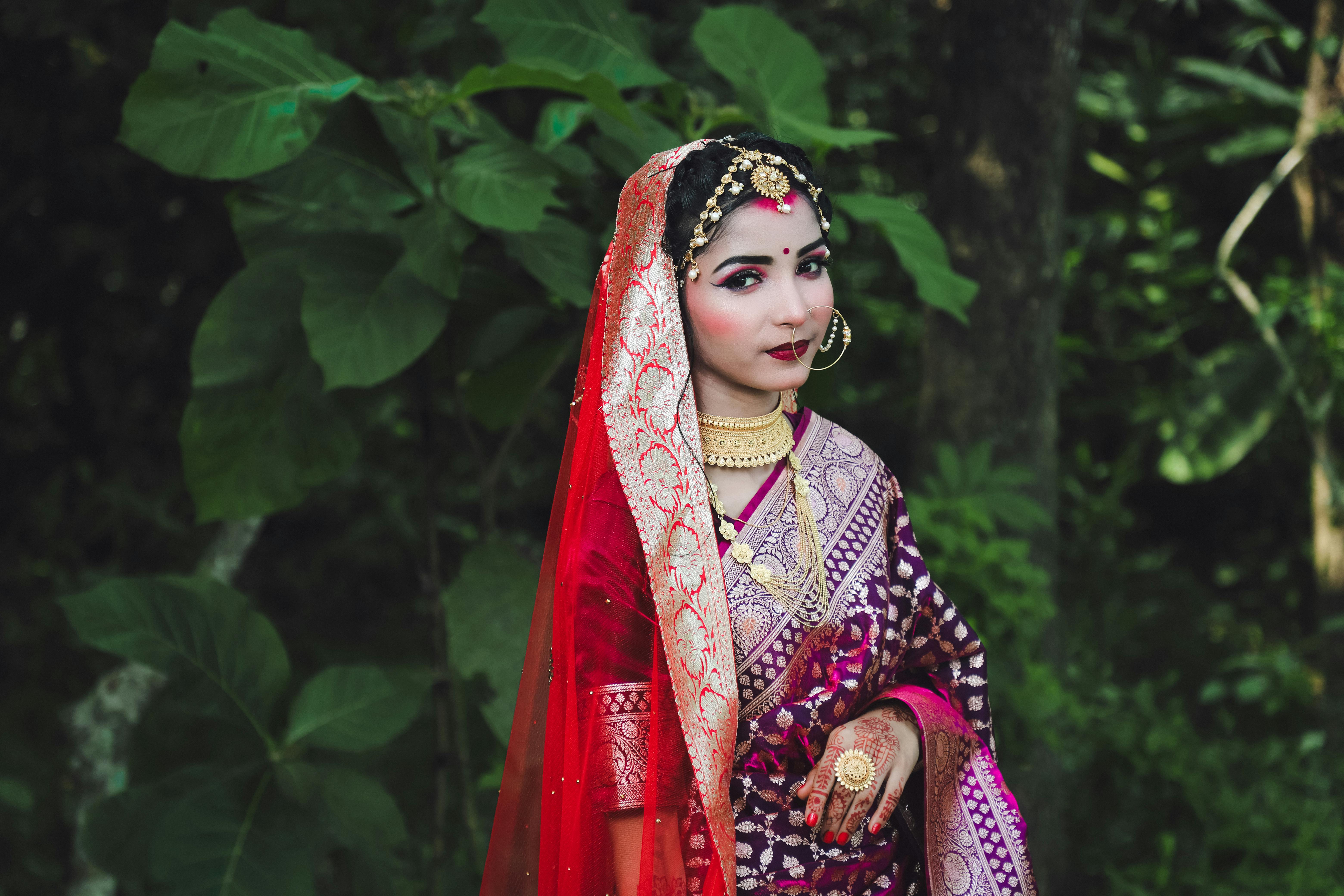 Young Bride Wearing a Red Veil and an Ornate Sari Posing in a Forest ...
