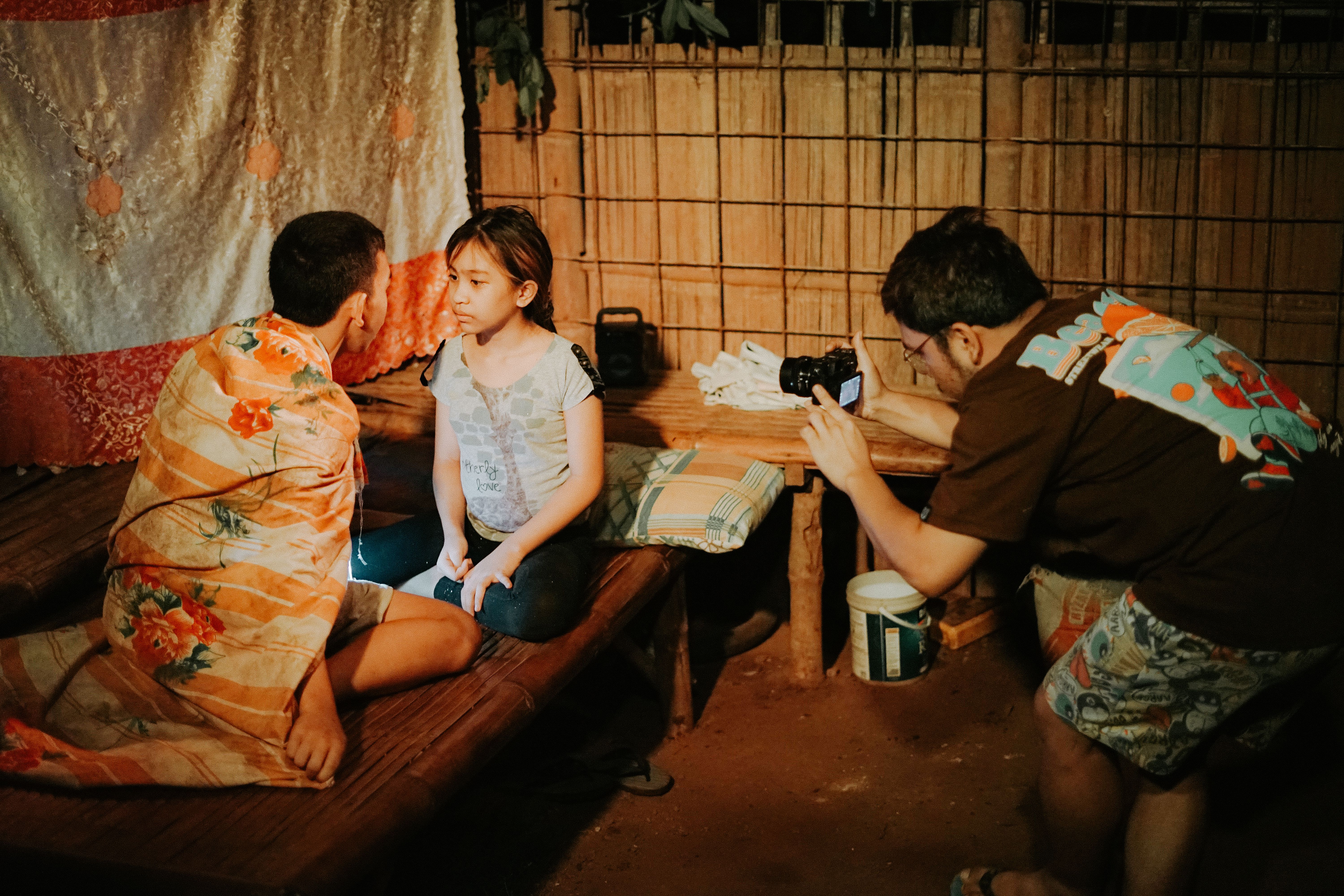 Man Photographing a Brother and his Sister Sitting Face to Face on a ...